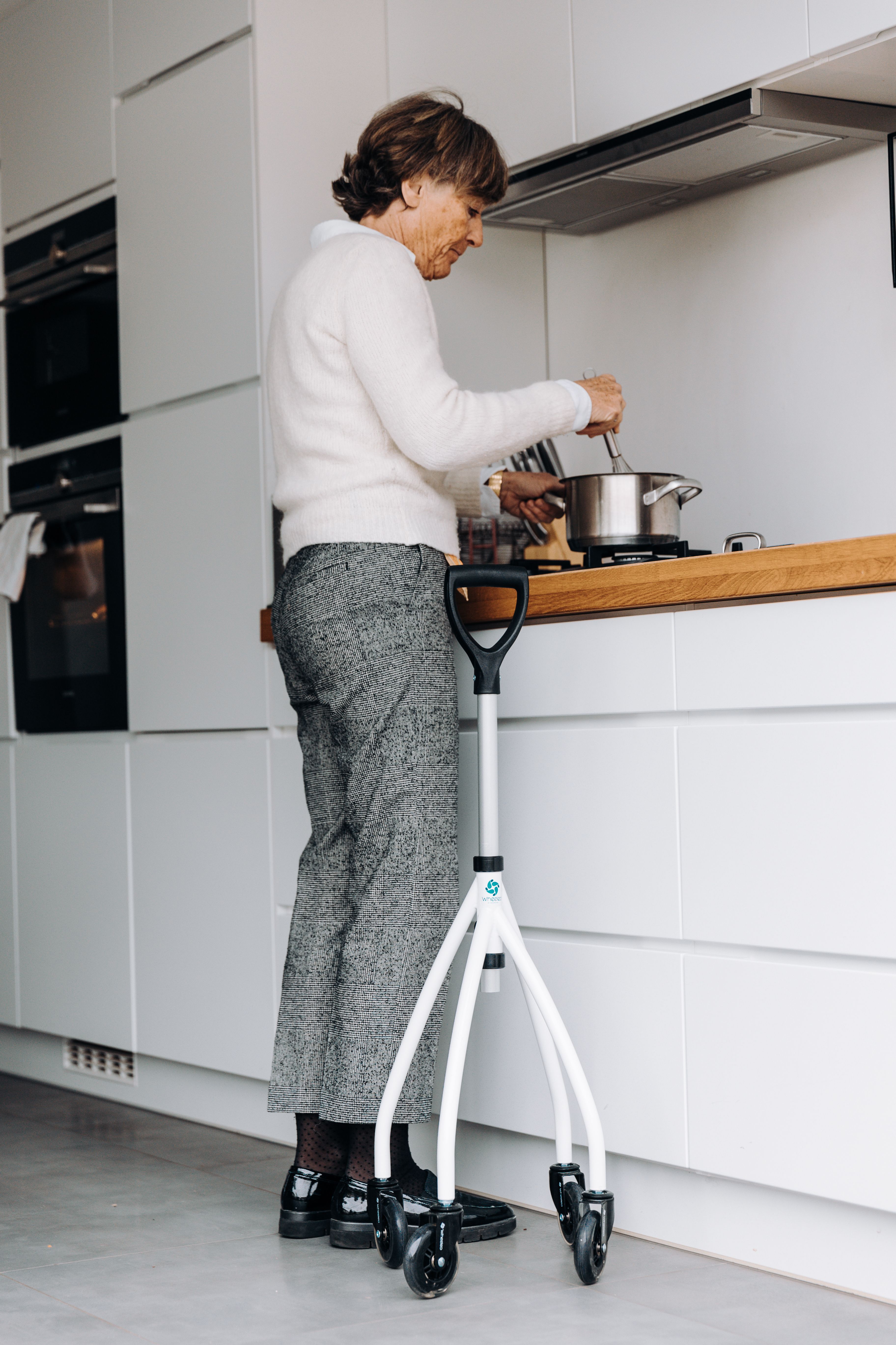 Senior Woman Cooking with Mobility Aid in Modern Kitchen · Free Stock Photo