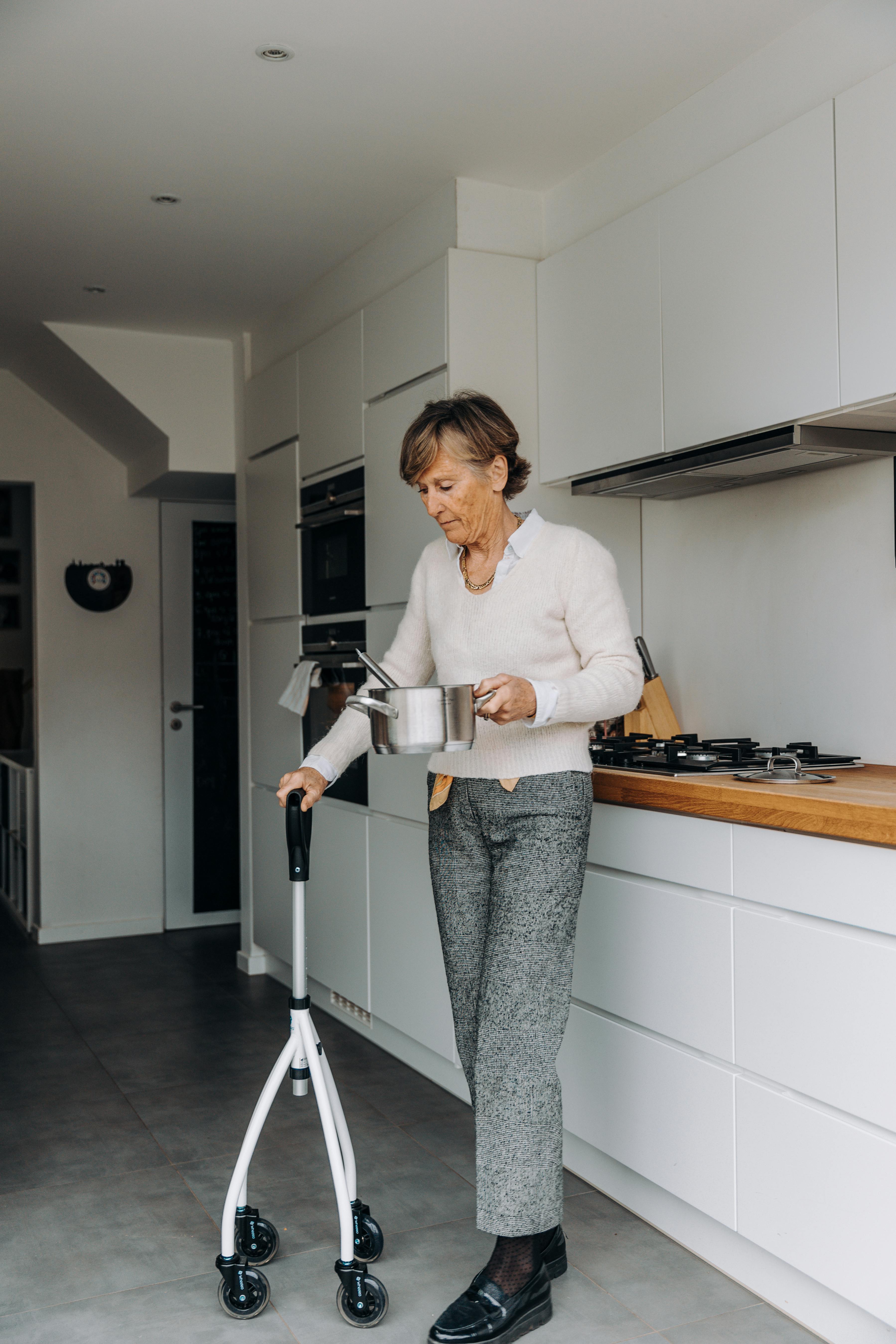 Senior Woman Using Walker in Modern Kitchen · Free Stock Photo