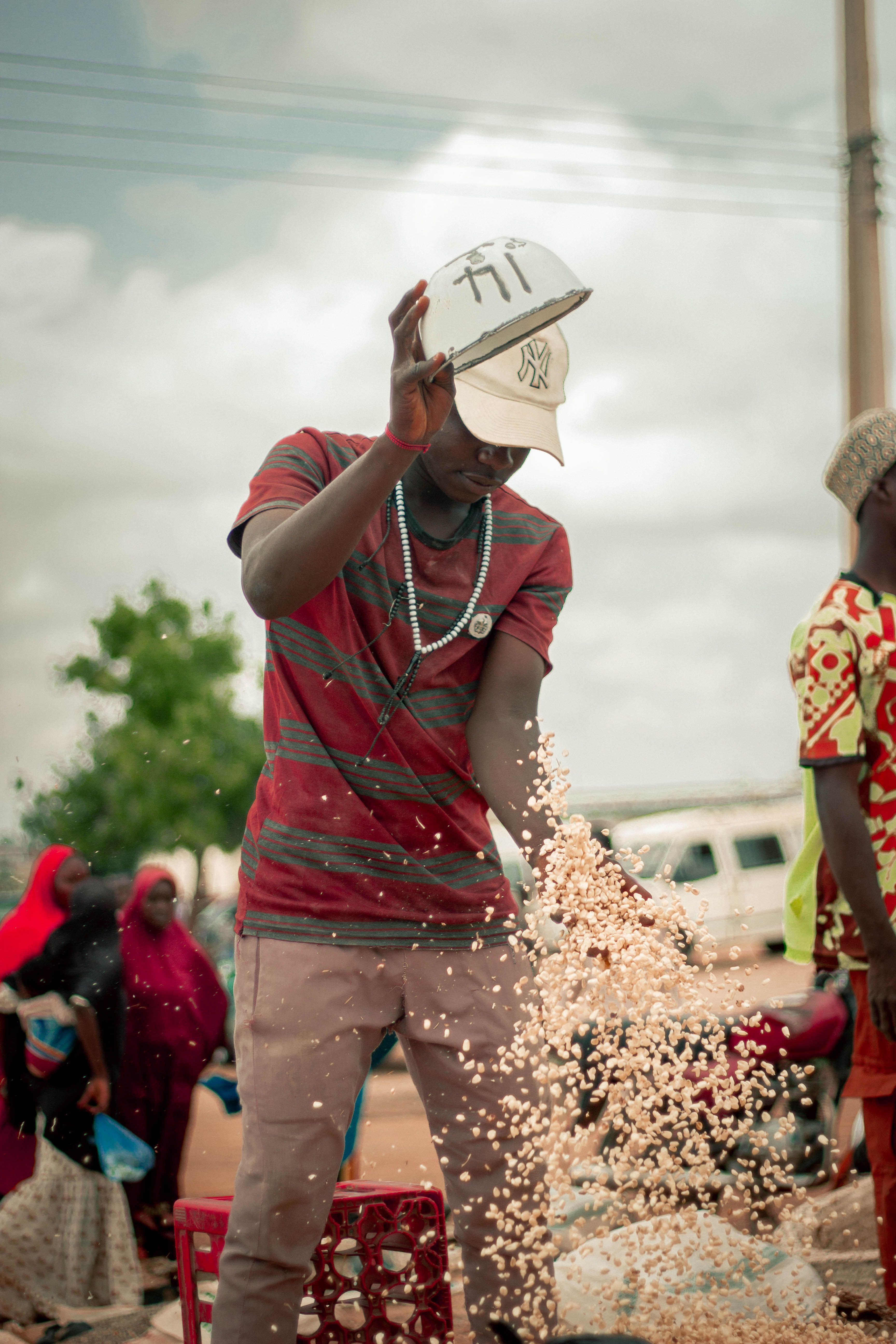 Man Sorting Grains in a Vibrant Outdoor Market · Free Stock Photo