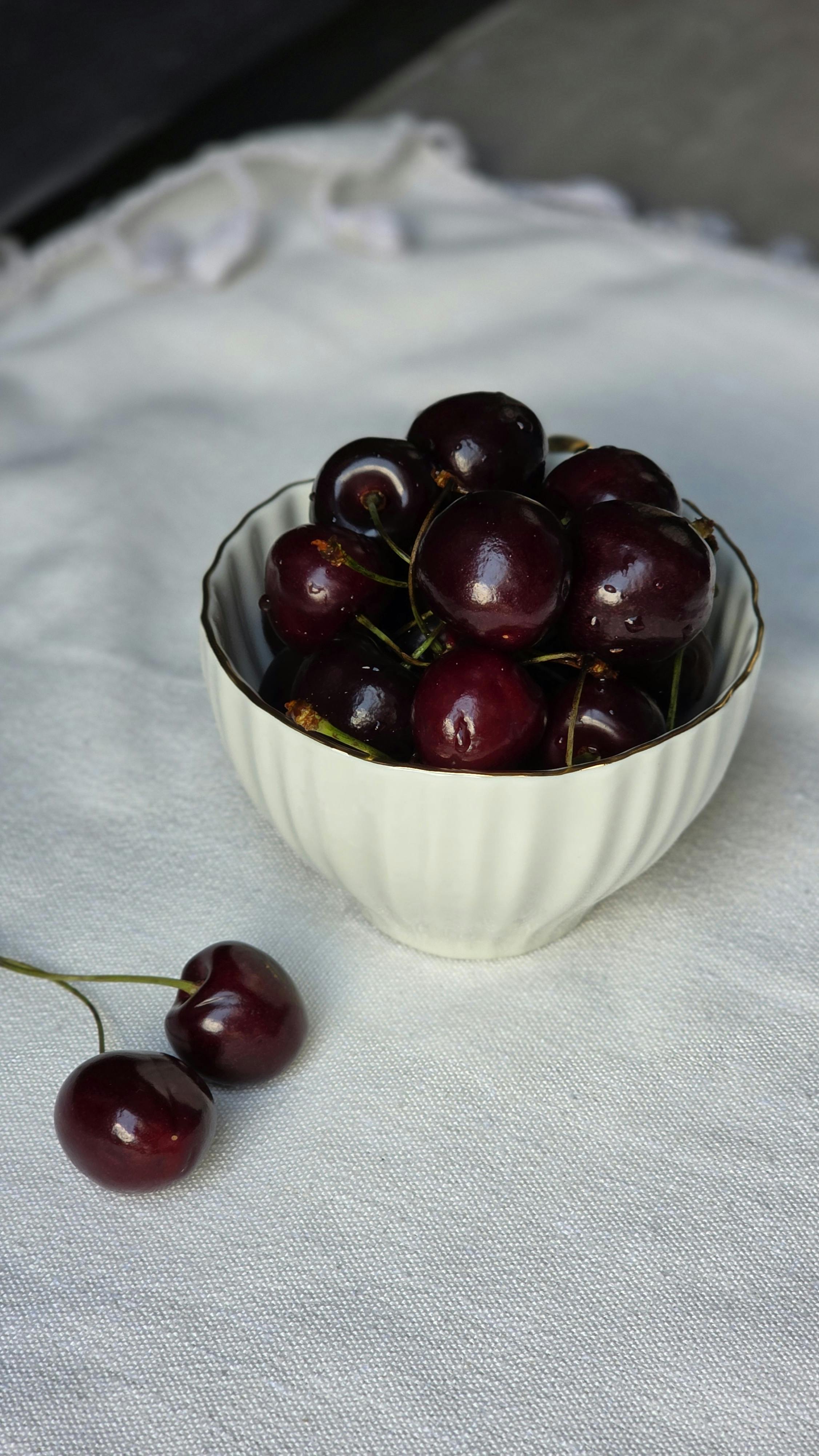 Bowl of Fresh Dark Cherries on White Cloth · Free Stock Photo