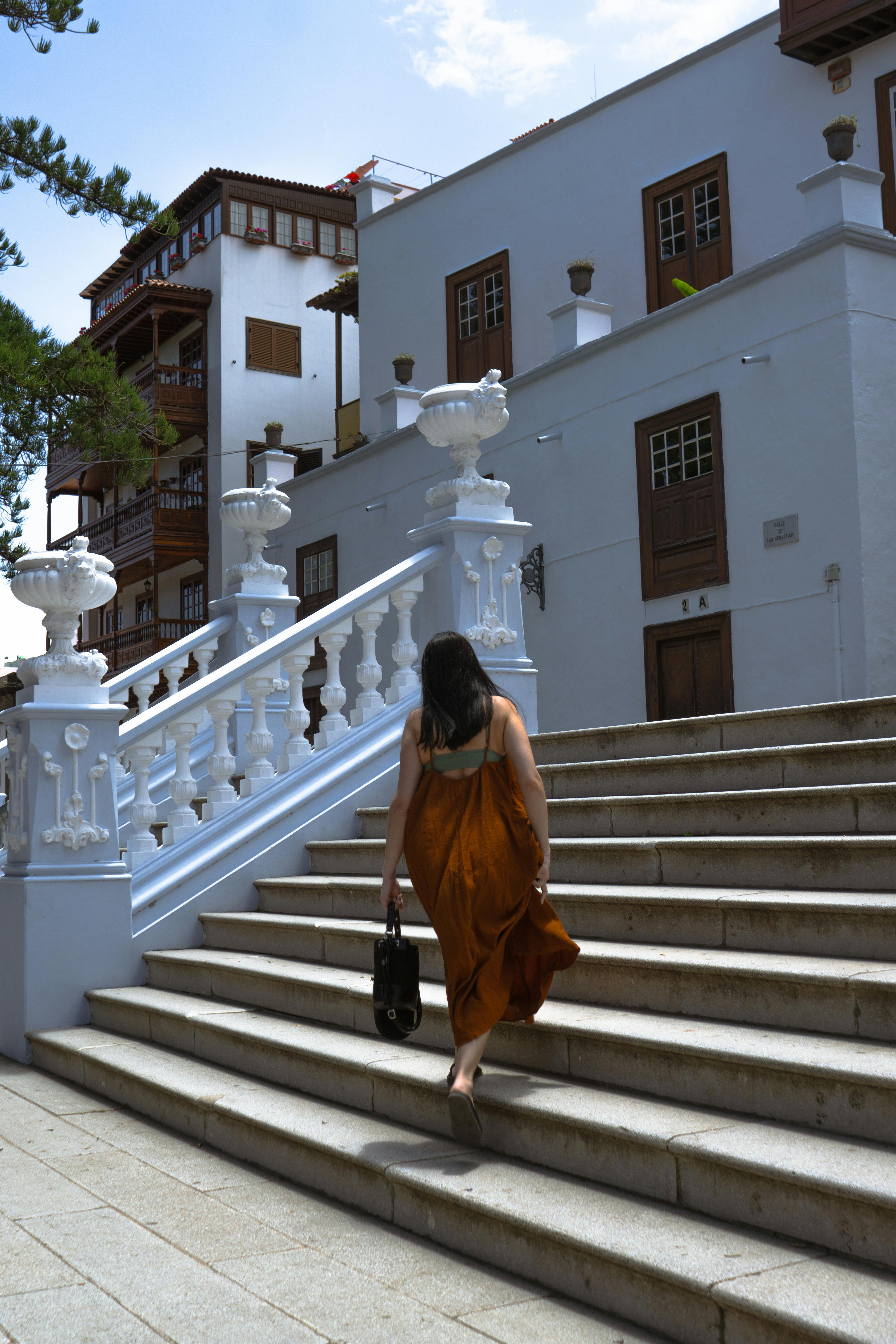 Woman Ascending Stone Stairs in Scenic Setting · Free Stock Photo