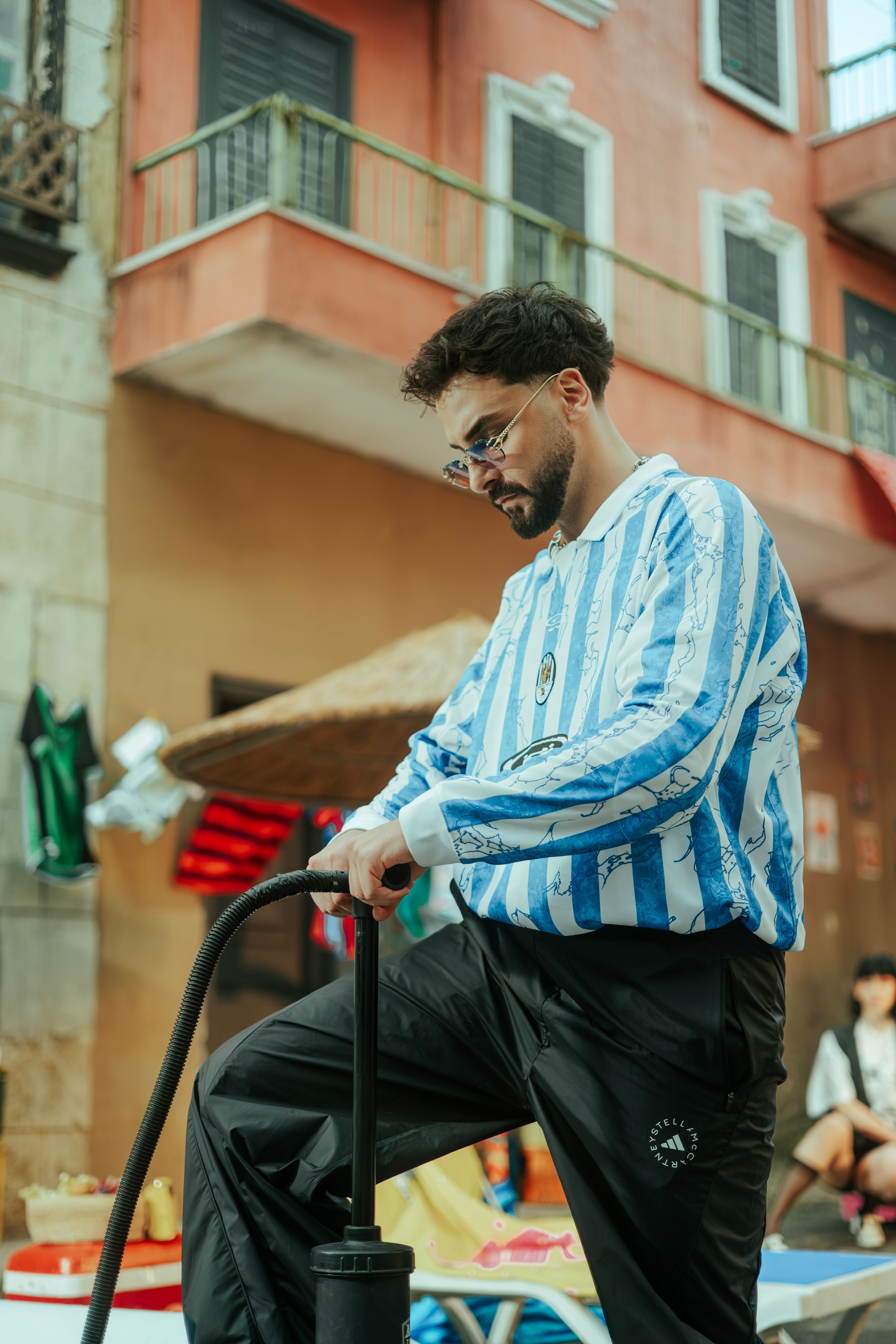 Man Inflating Pool Toy in Urban Setting · Free Stock Photo