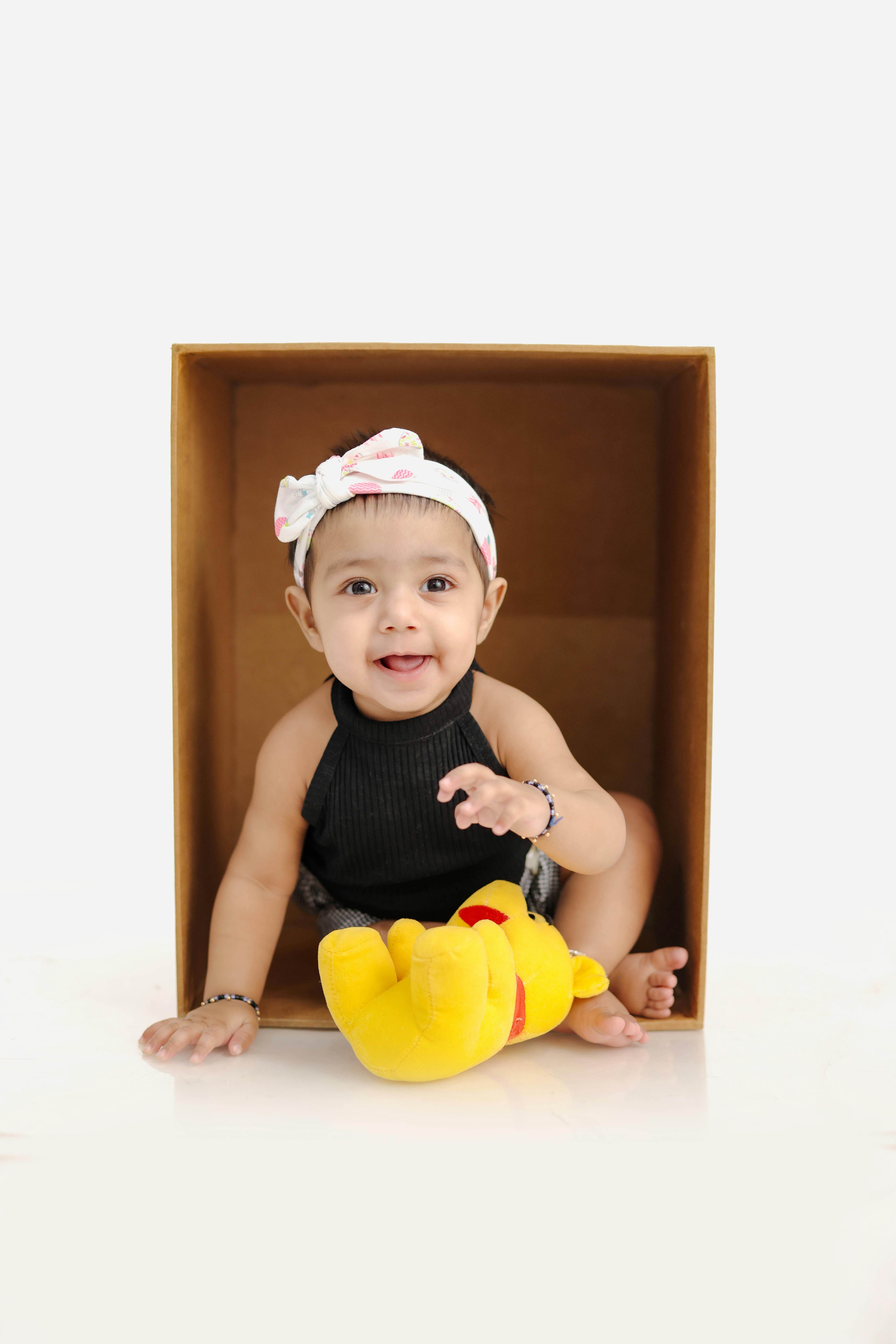 Adorable Baby in Box with Toy and Headband · Free Stock Photo