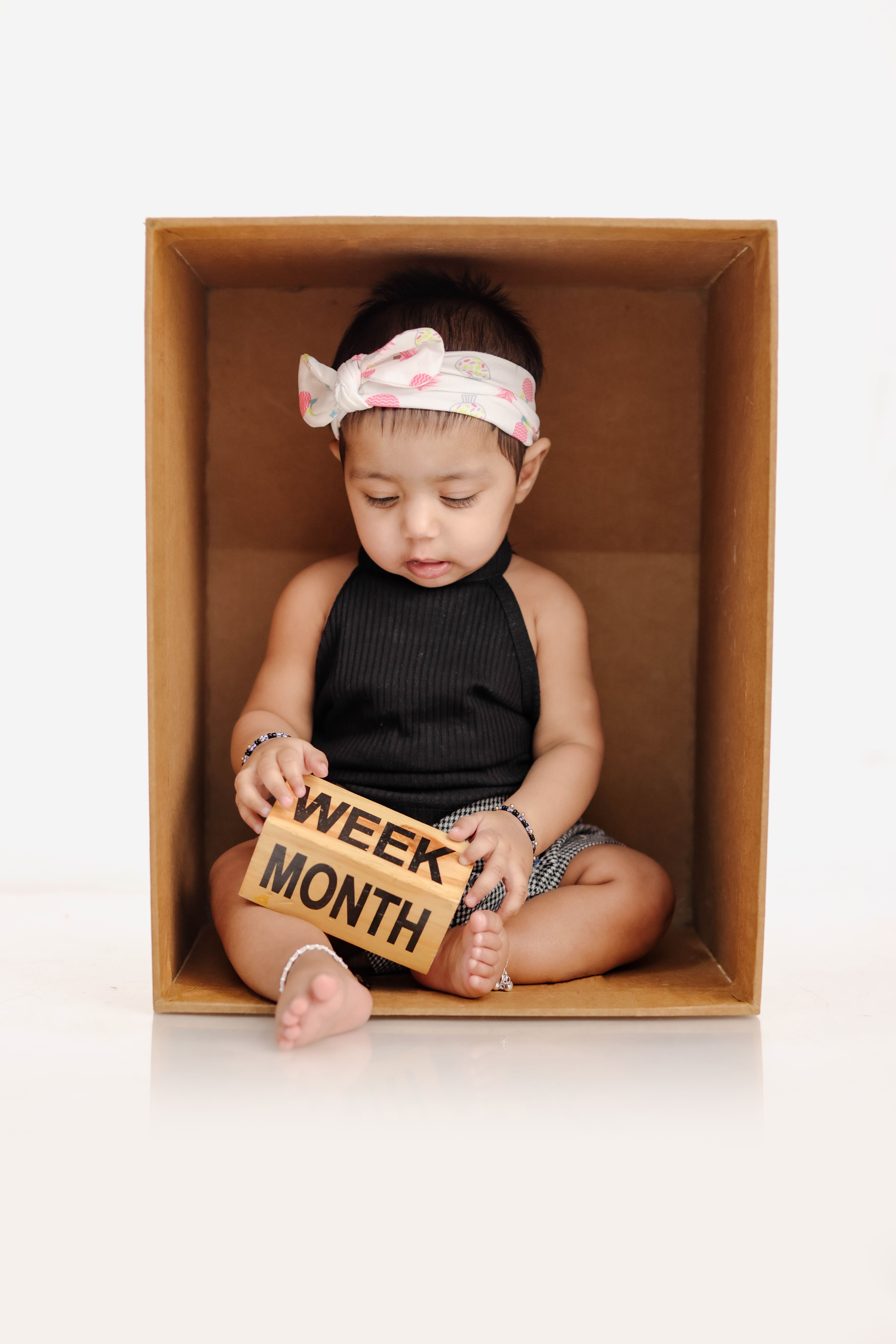 Adorable Baby in a Box Holding Milestone Blocks · Free Stock Photo