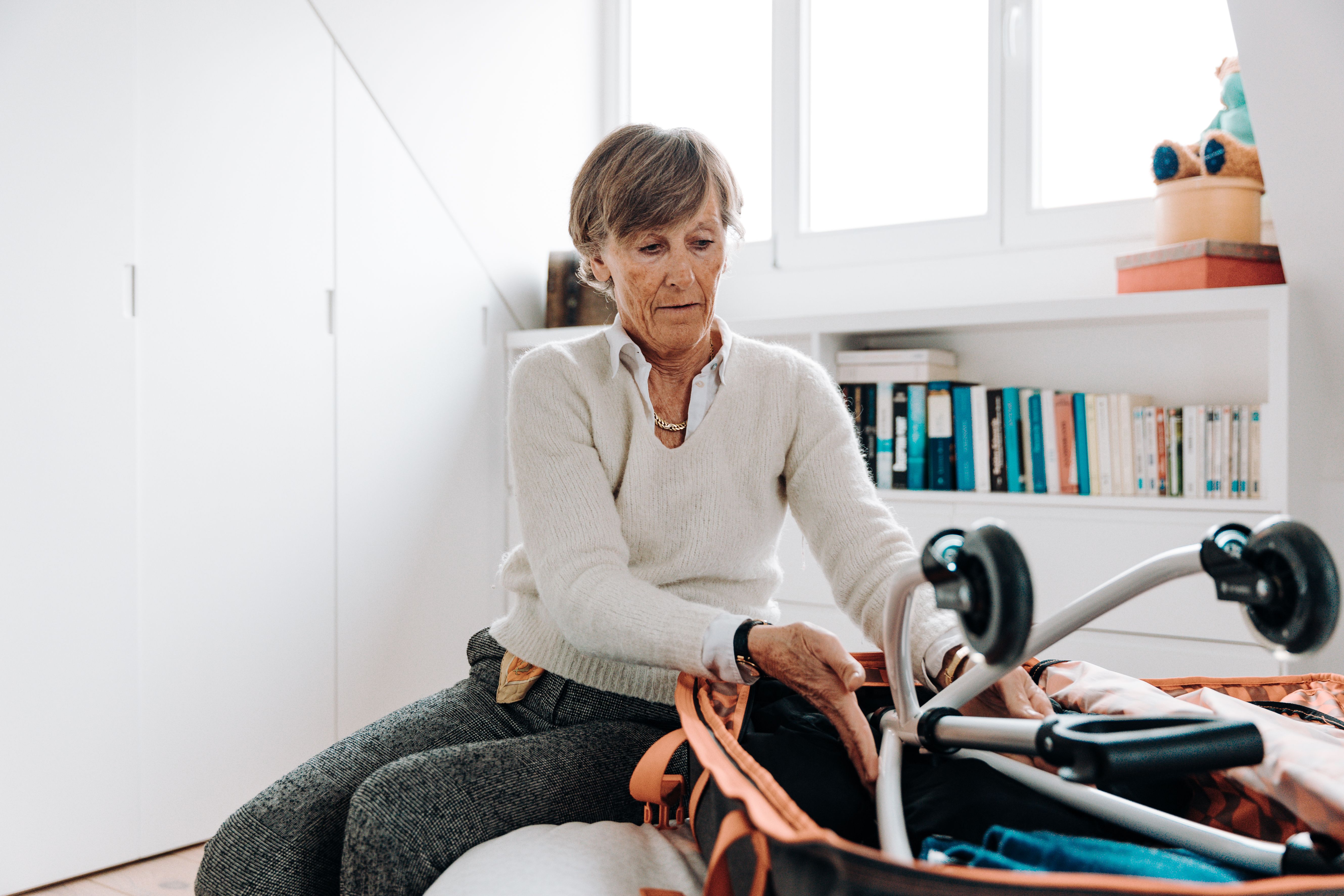 Senior Woman Packing Suitcase with Rollator · Free Stock Photo
