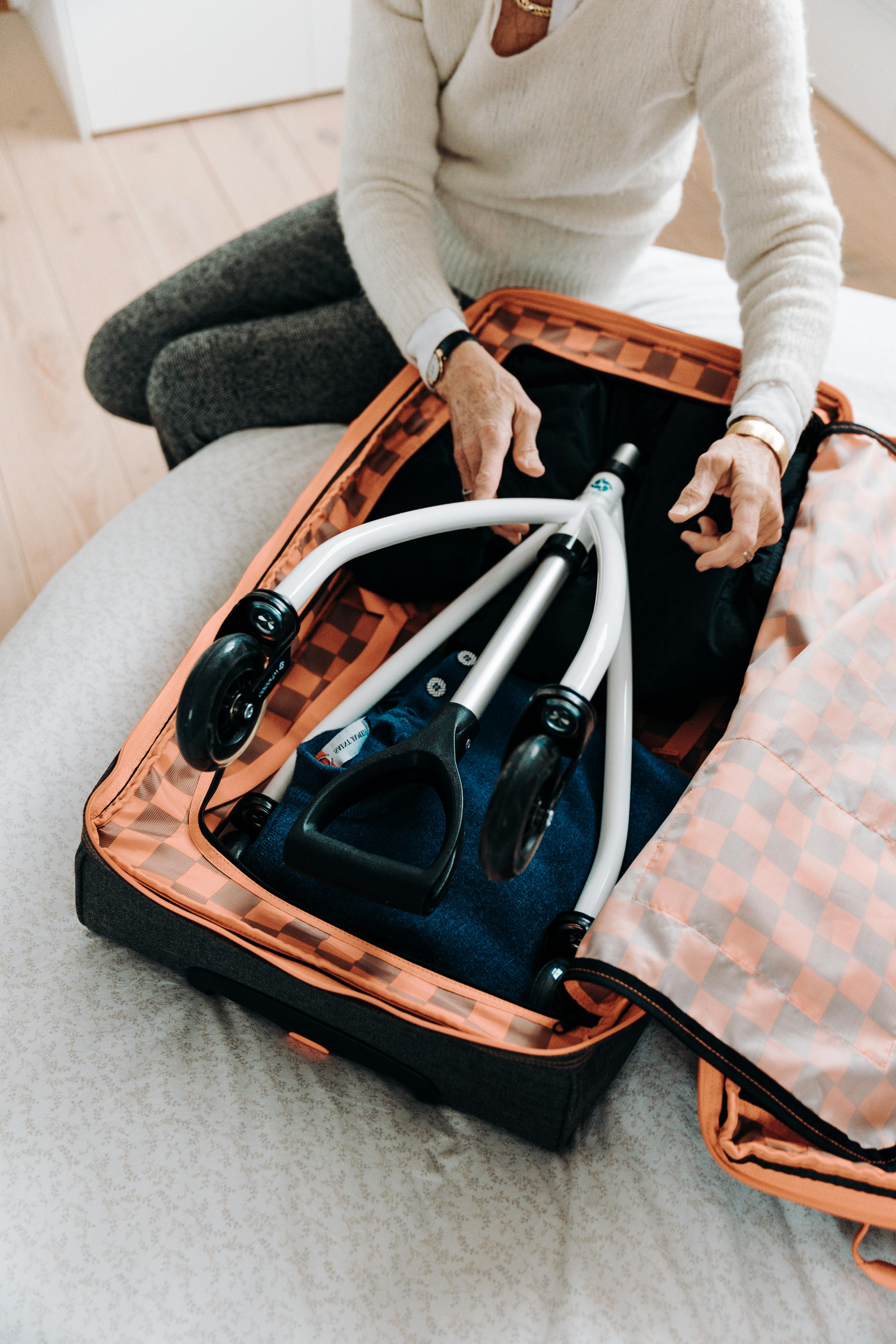 Senior Adult Packing a Rollator into Suitcase · Free Stock Photo