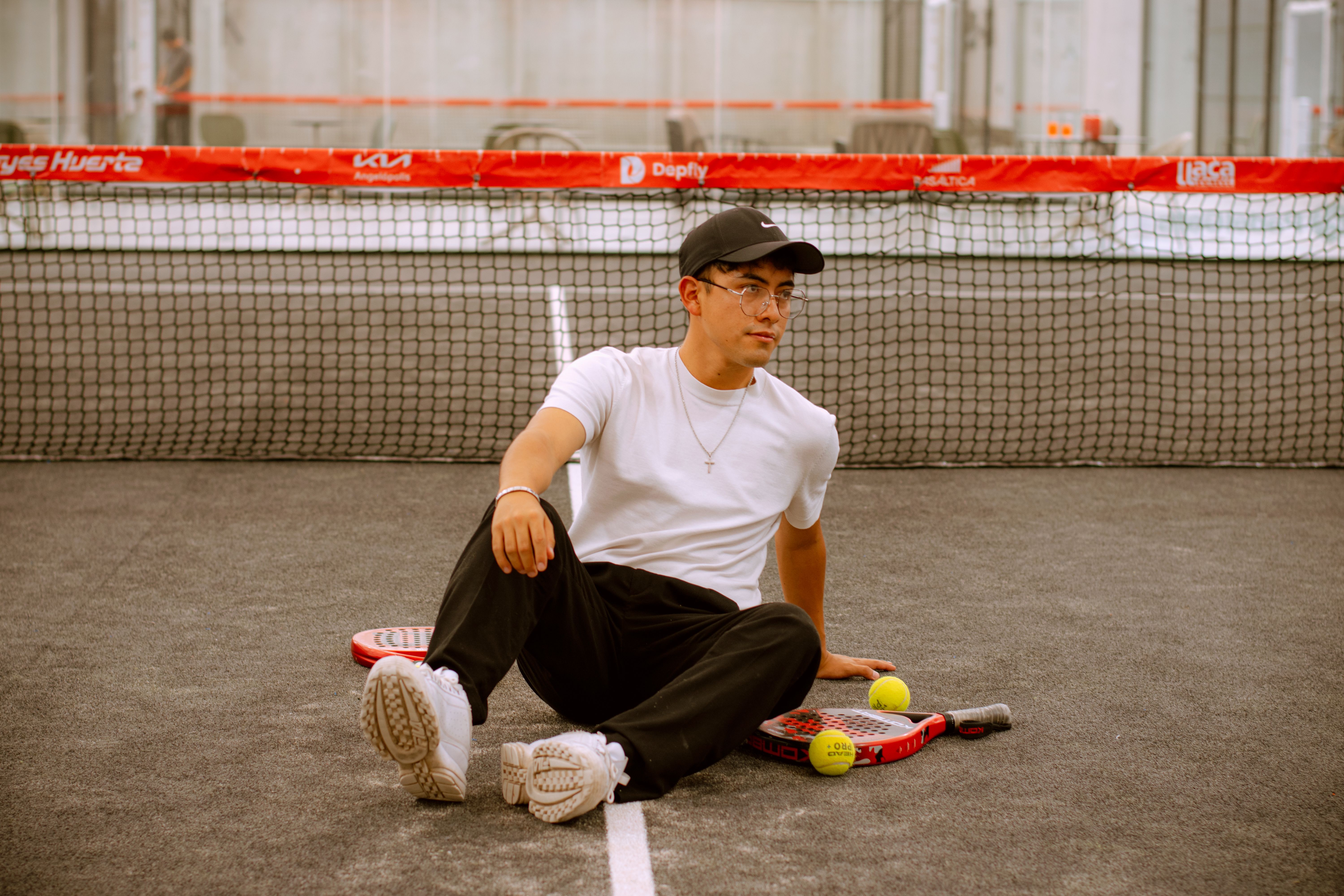 Young man resting on a padel court · Free Stock Photo