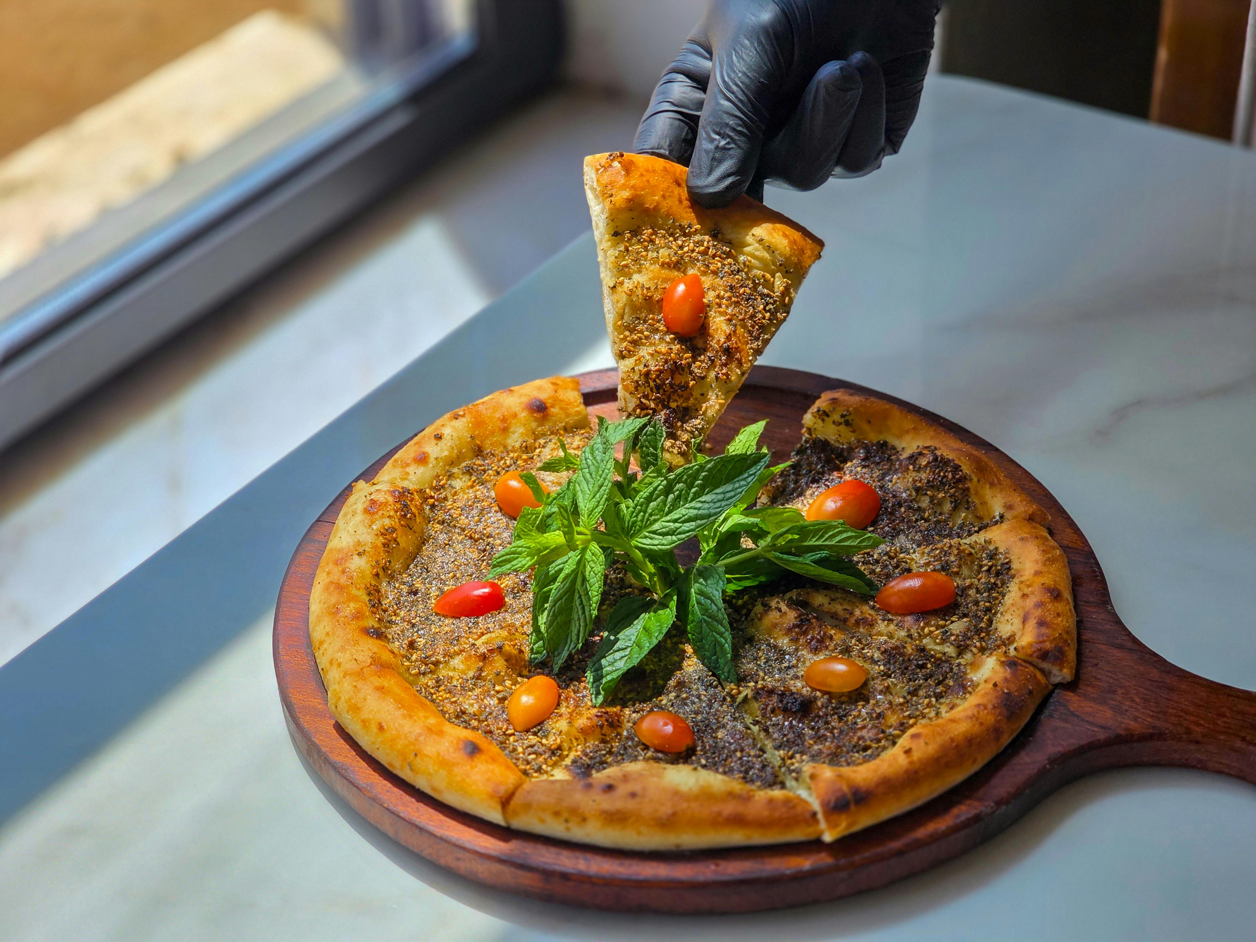 Delicious Zaatar Pizza Slice with Cherry Tomatoes · Free Stock Photo
