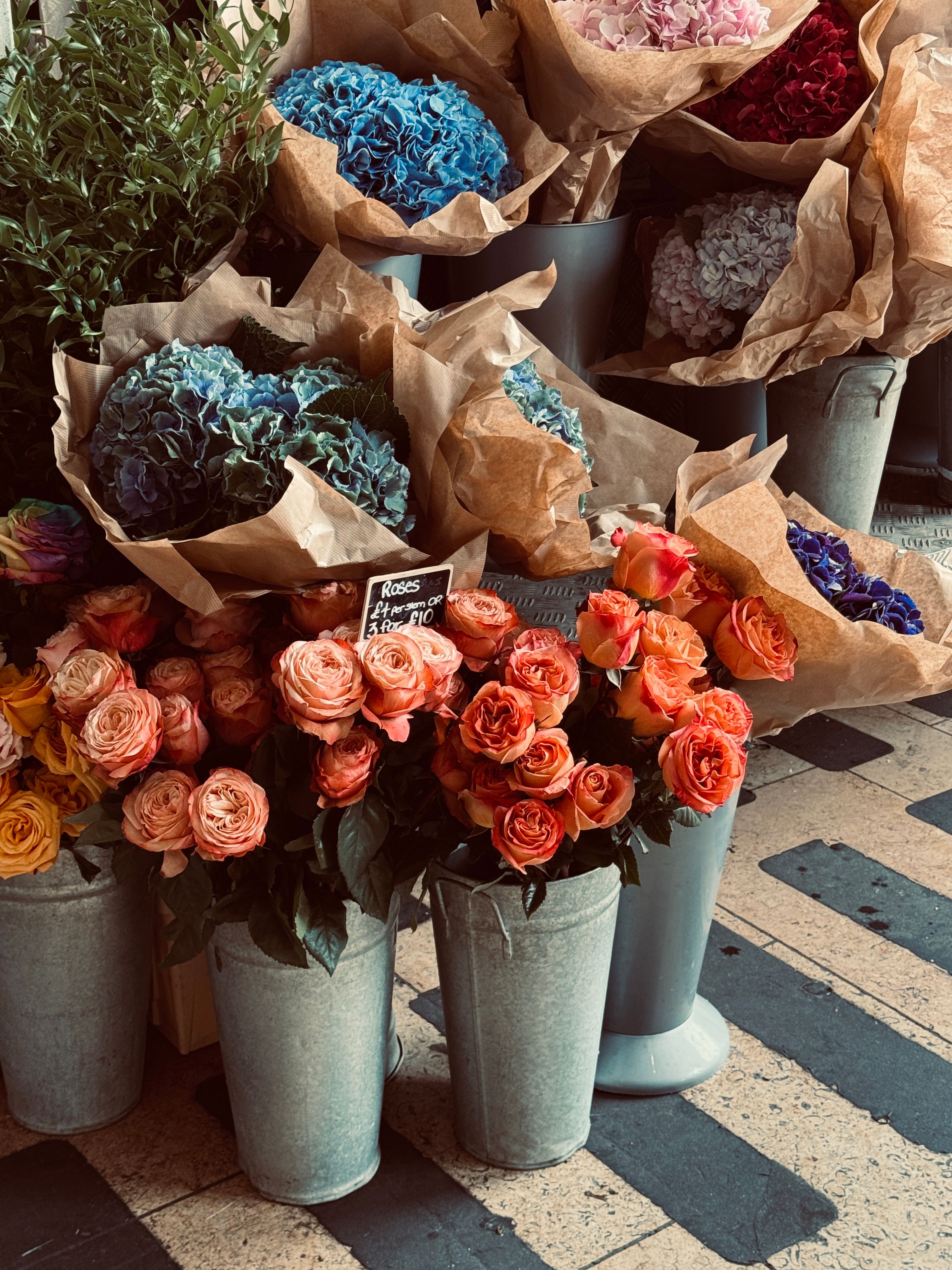 Vibrant Flower Shop Display with Roses and Hydrangeas · Free Stock Photo