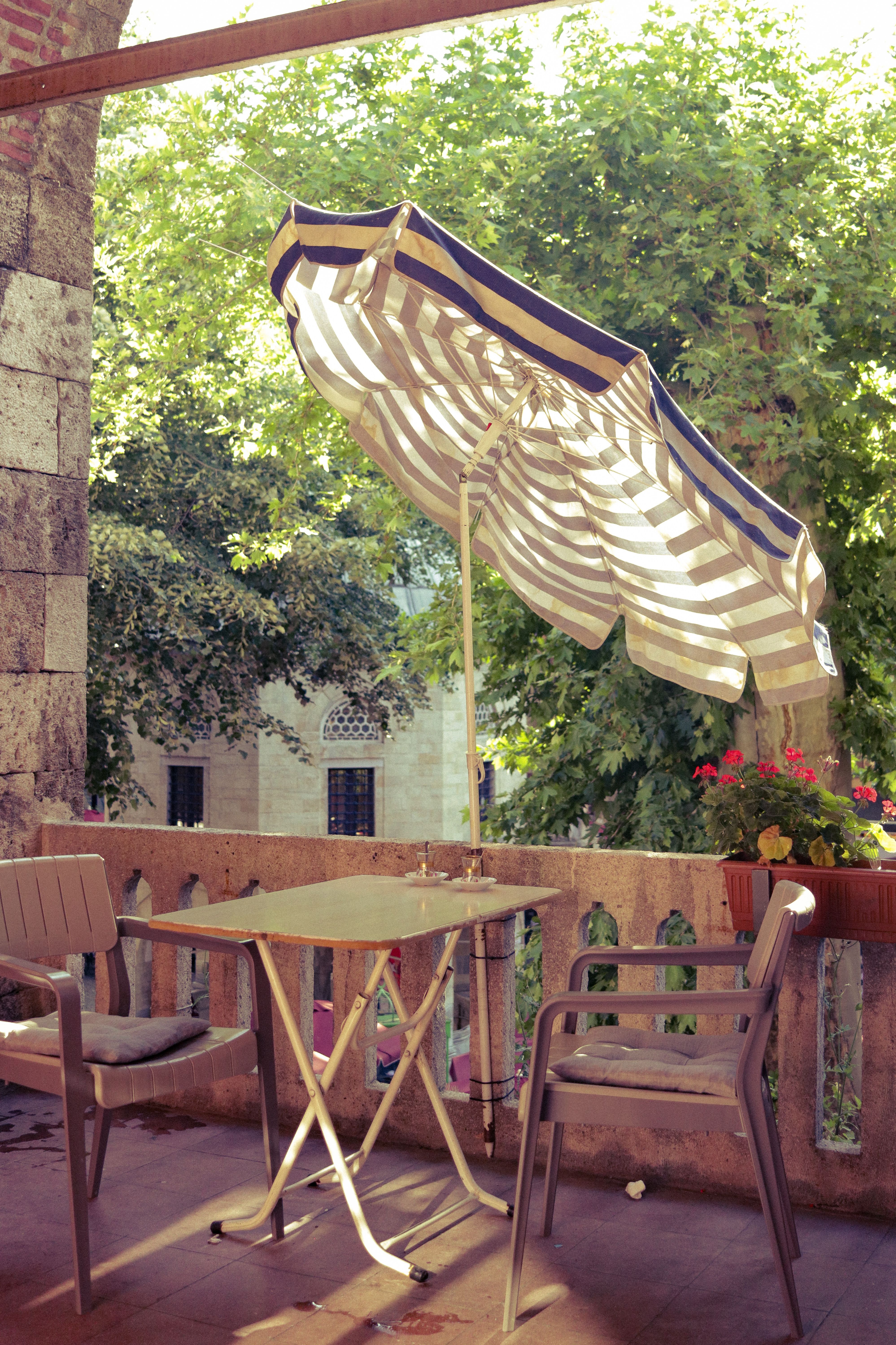 Charming Outdoor Patio with Striped Umbrella · Free Stock Photo