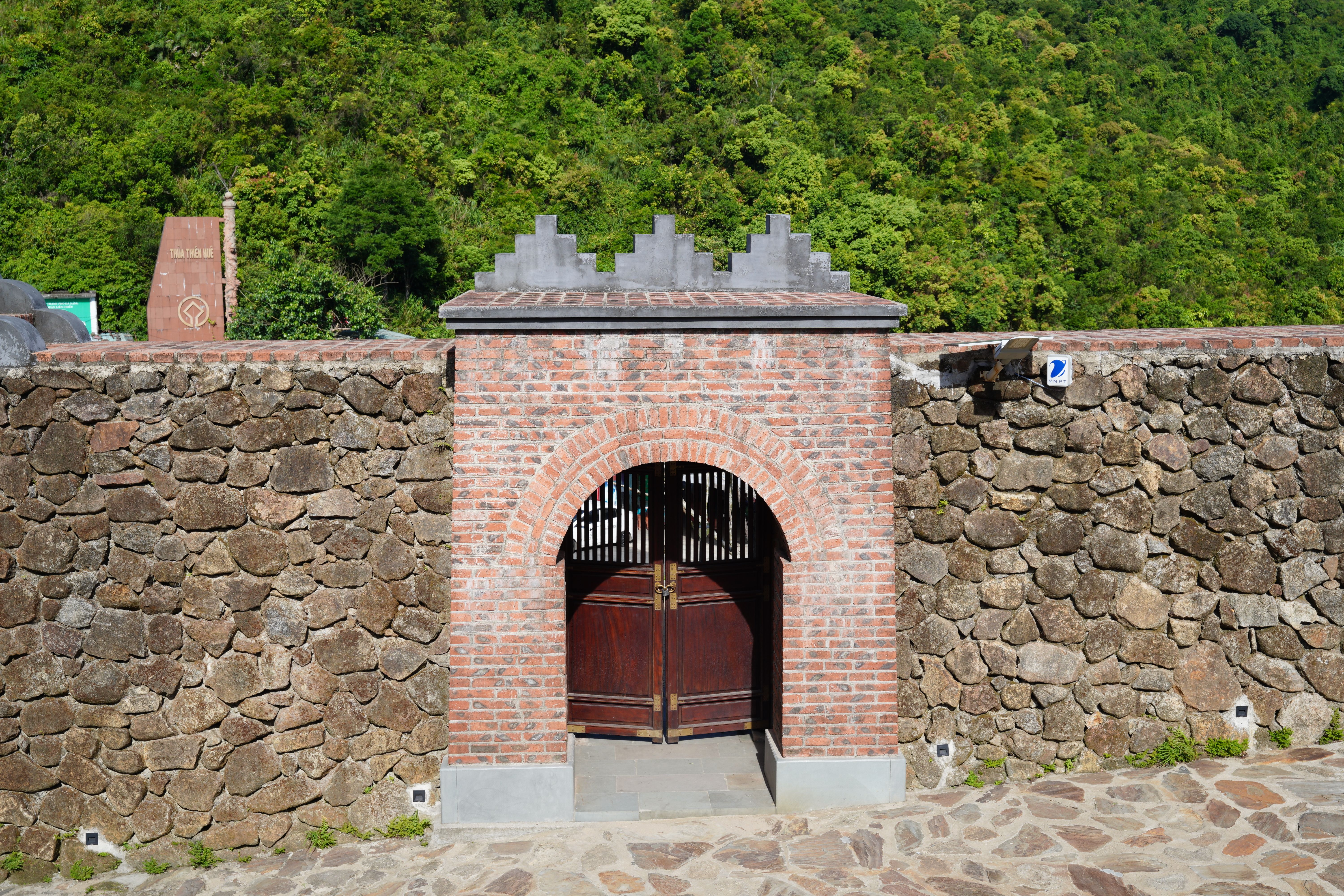 Historic Stone Gate Entrance Amidst Lush Greenery · Free Stock Photo