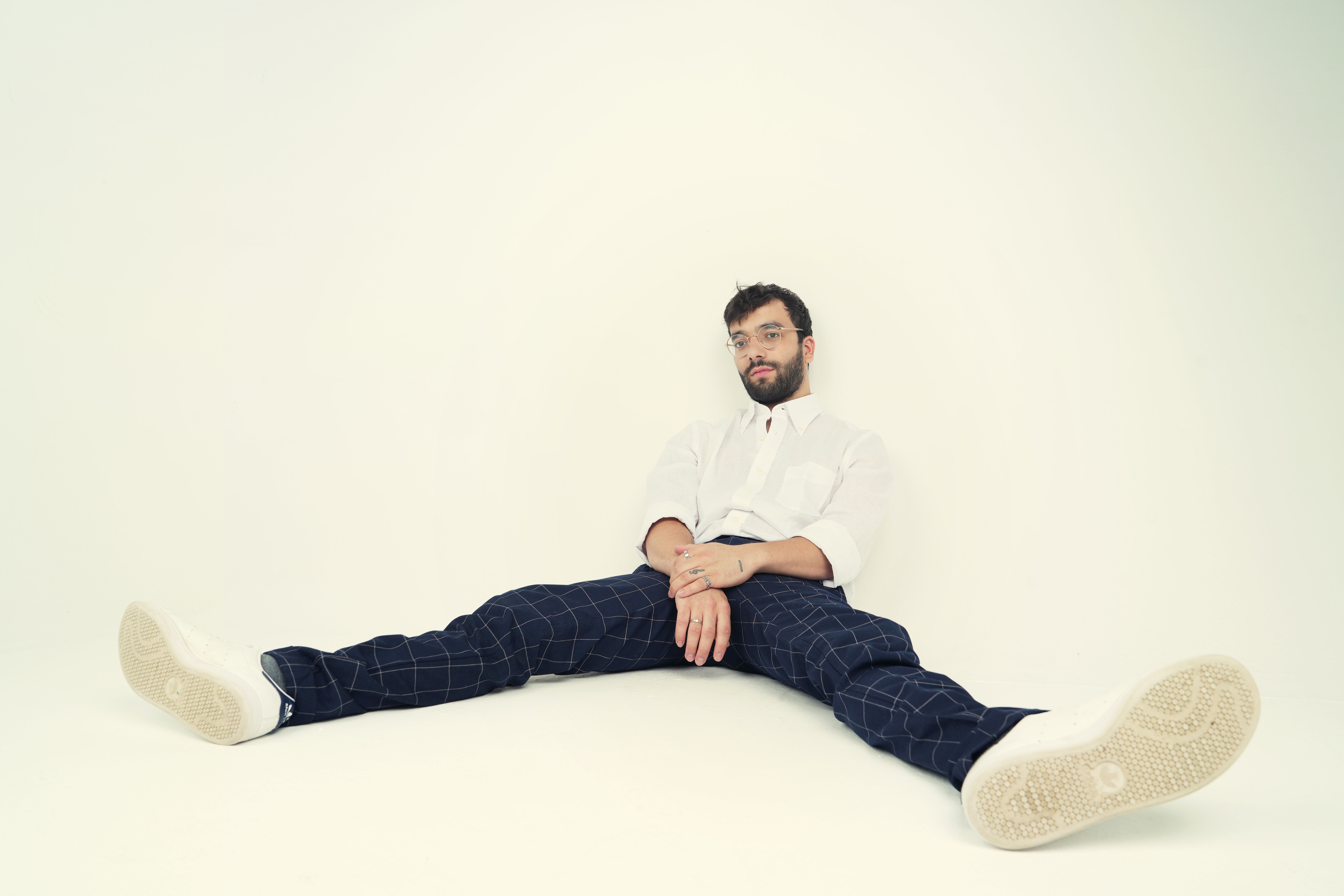 Stylish Man Sitting Casually in Minimalist Space · Free Stock Photo