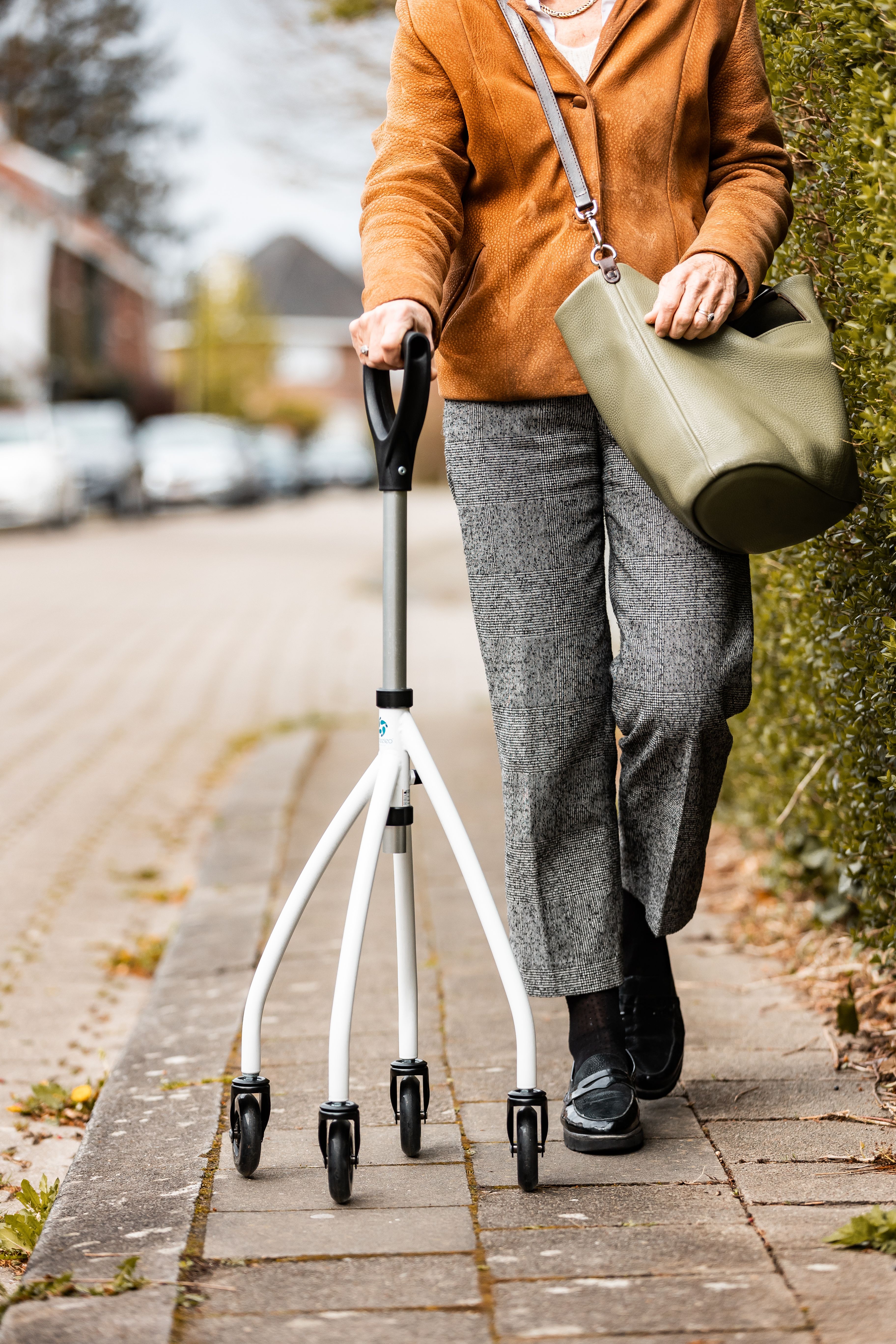 Senior Woman Using Rollator on Urban Sidewalk · Free Stock Photo