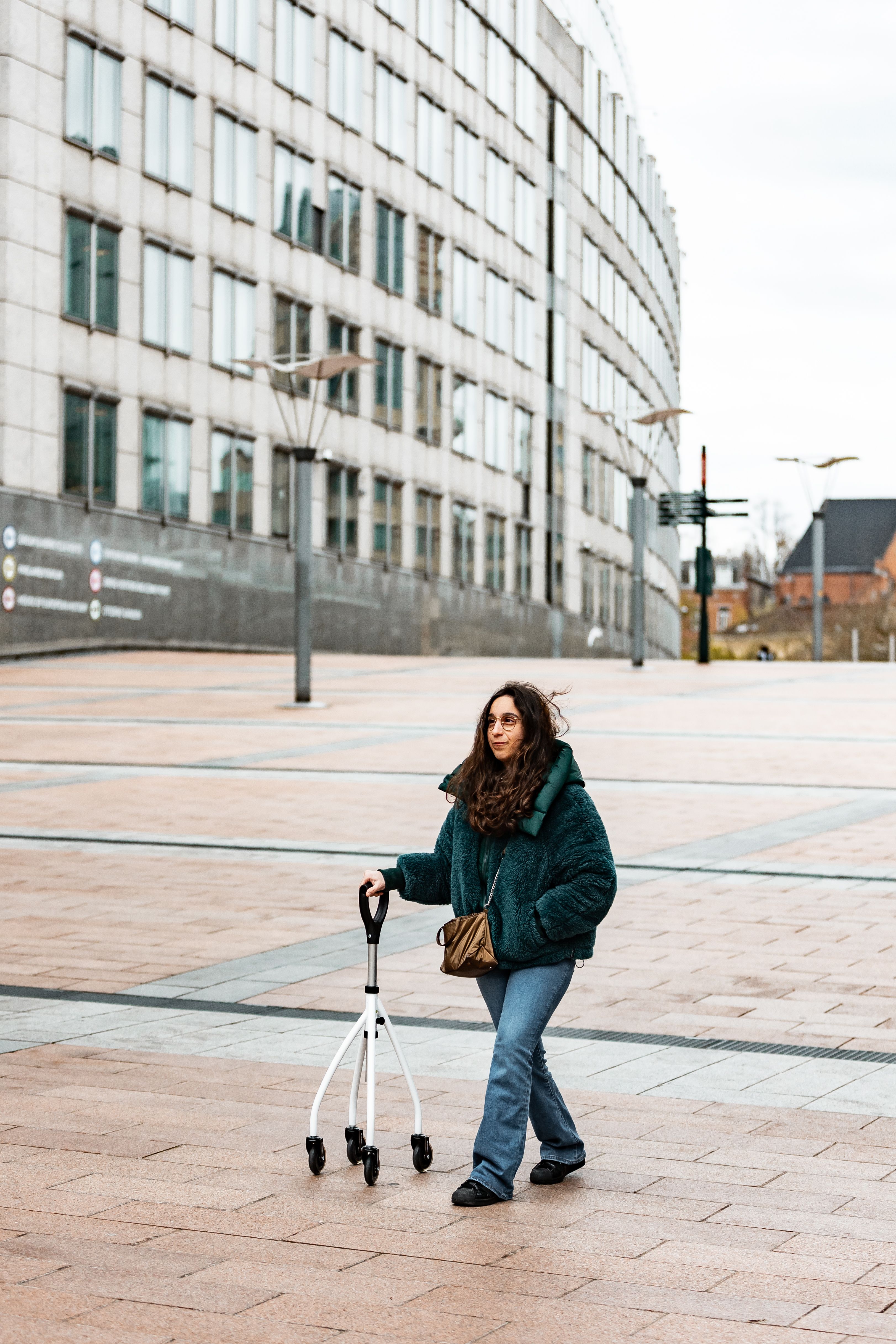 Woman Walking with Rollator in Urban Plaza · Free Stock Photo