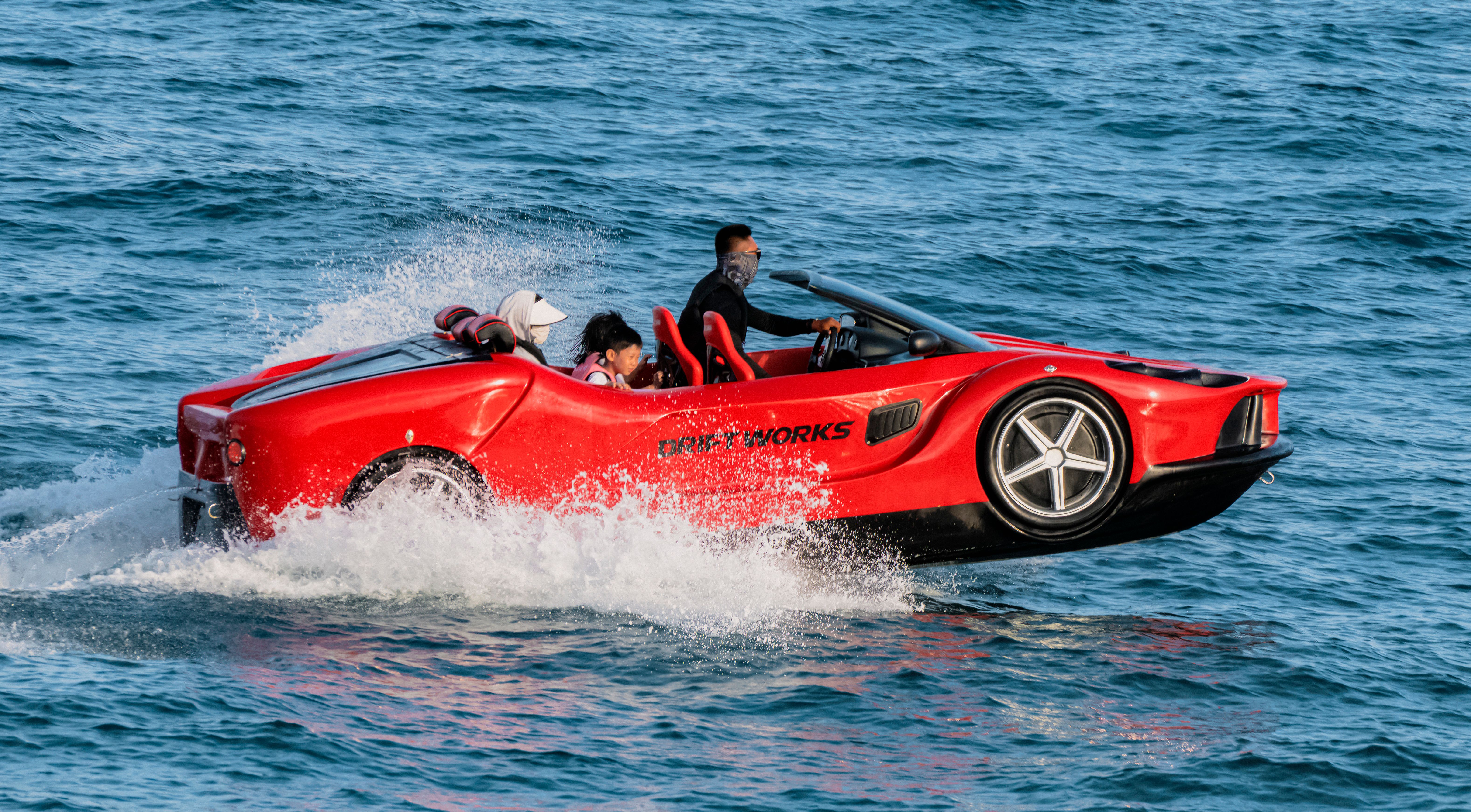 Red Amphibious Sports Car on Water Adventure · Free Stock Photo