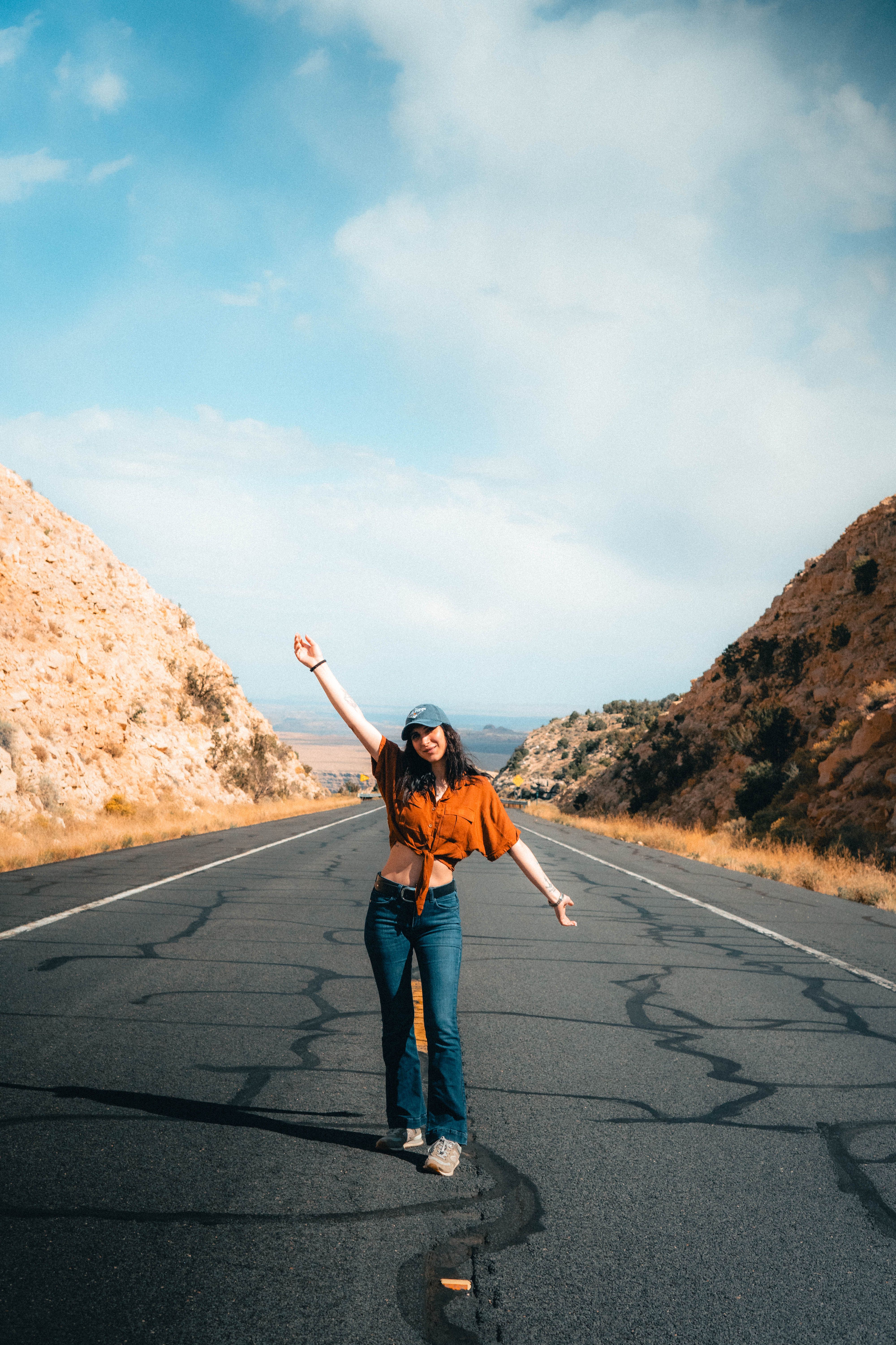 Woman Embracing Freedom on a Desert Highway · Free Stock Photo