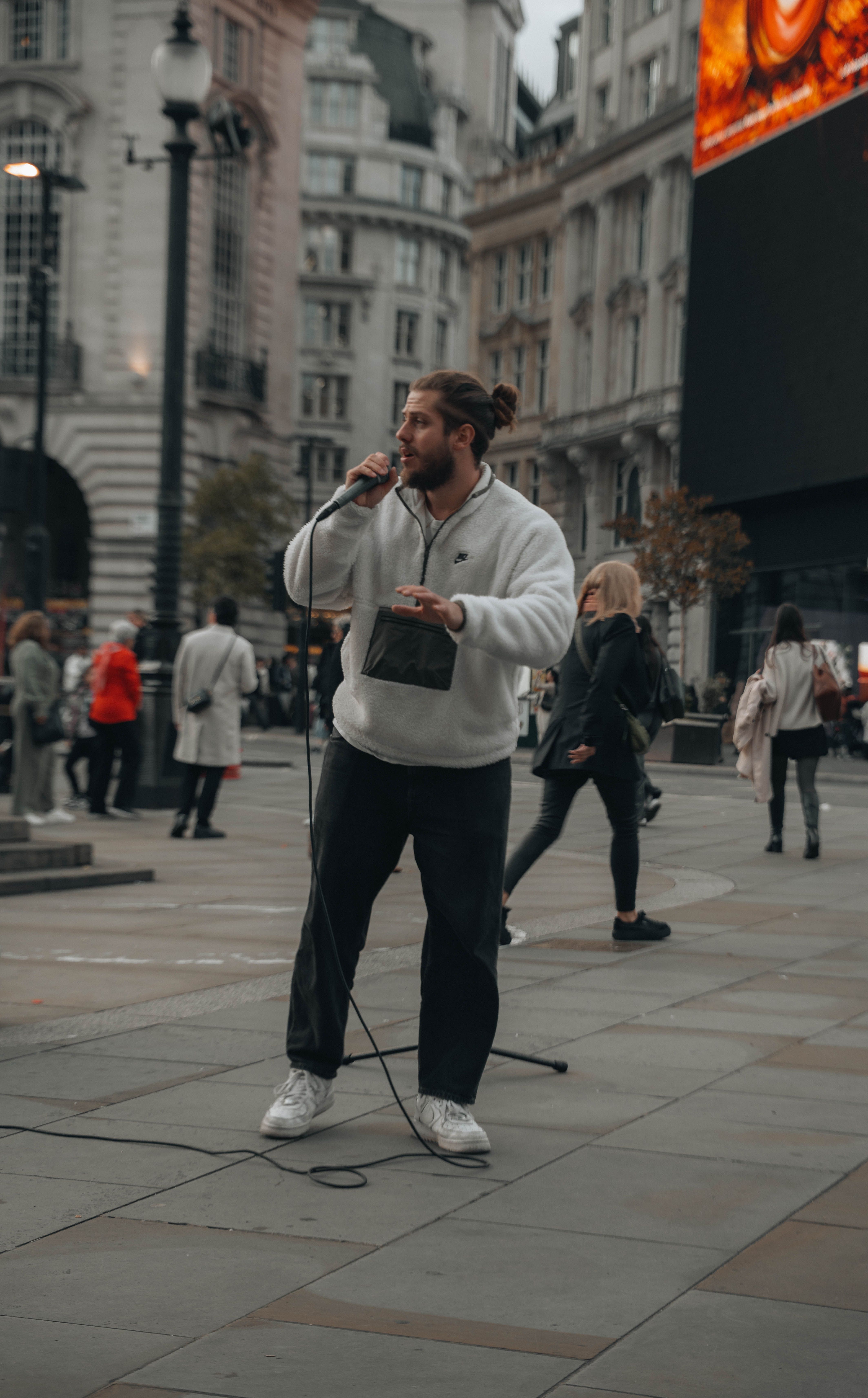 Street Performer Singing in Urban Setting · Free Stock Photo
