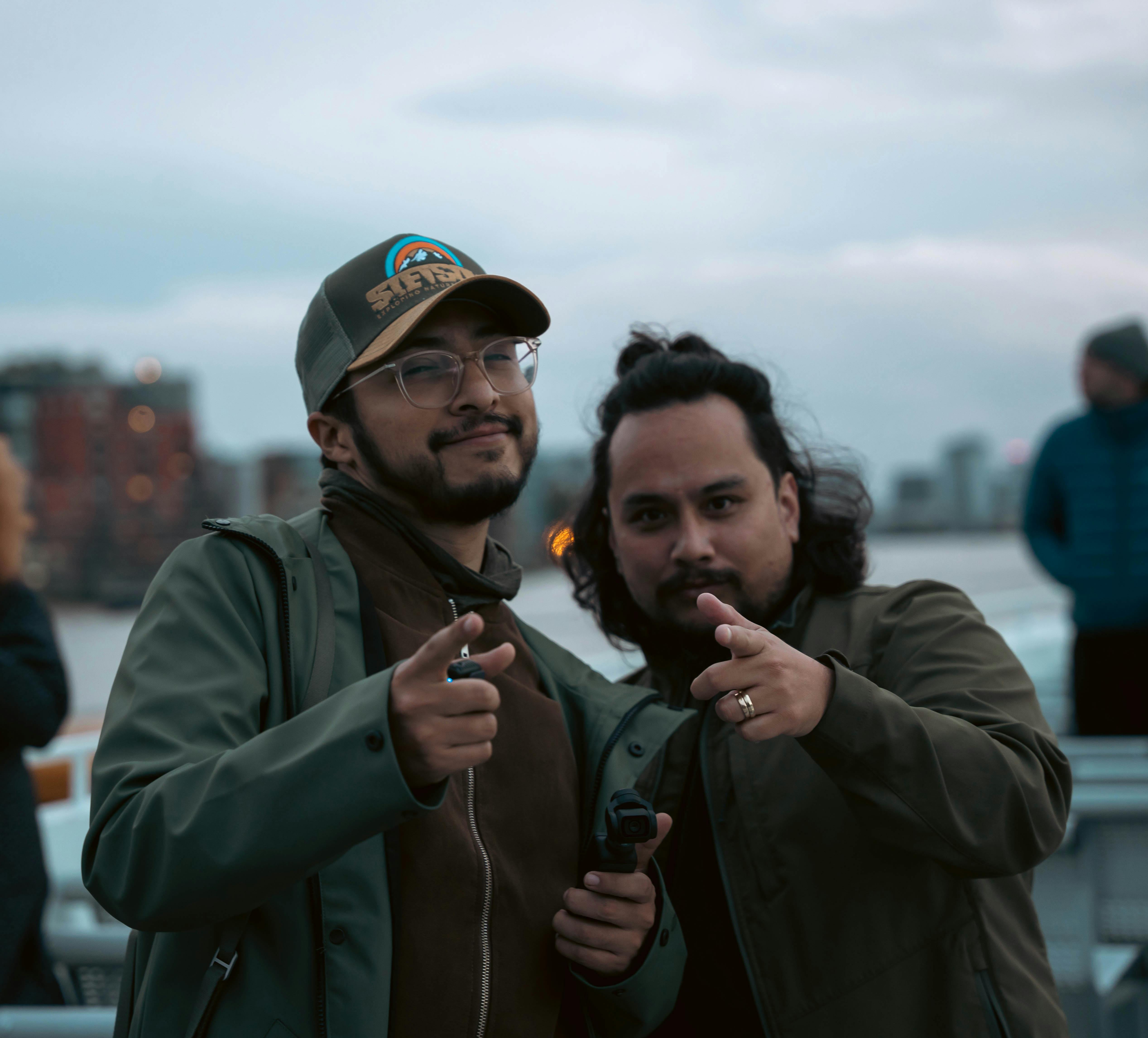 Two Friends Smiling and Pointing Outdoors · Free Stock Photo
