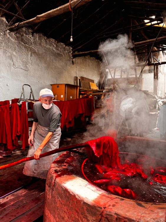 Traditional Textile Dyeing Workshop with Red Fabrics · Free Stock Photo