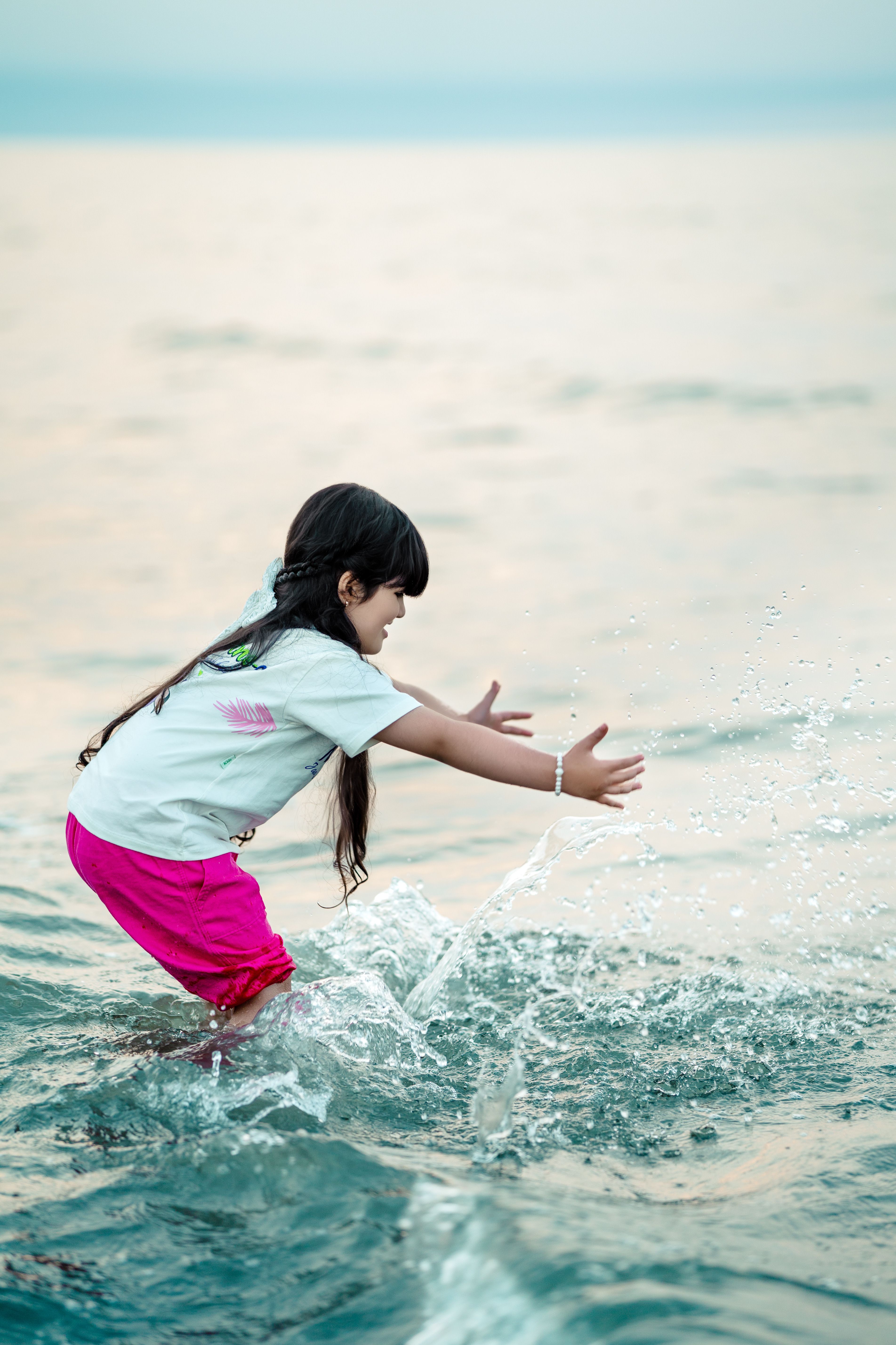 Child Playing in Ocean Waves at Sunset · Free Stock Photo