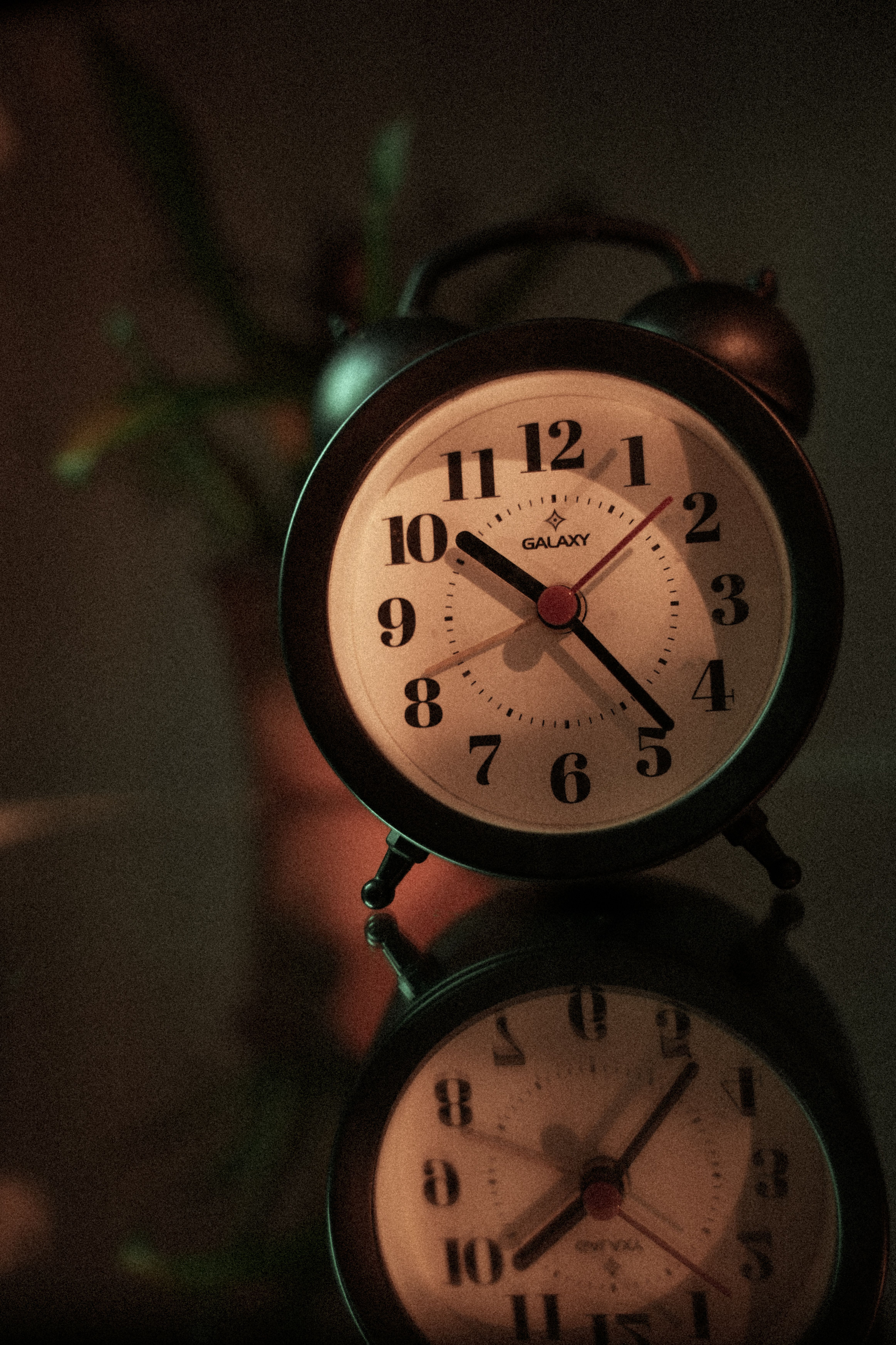 Vintage Alarm Clock Reflection on Glass Surface · Free Stock Photo