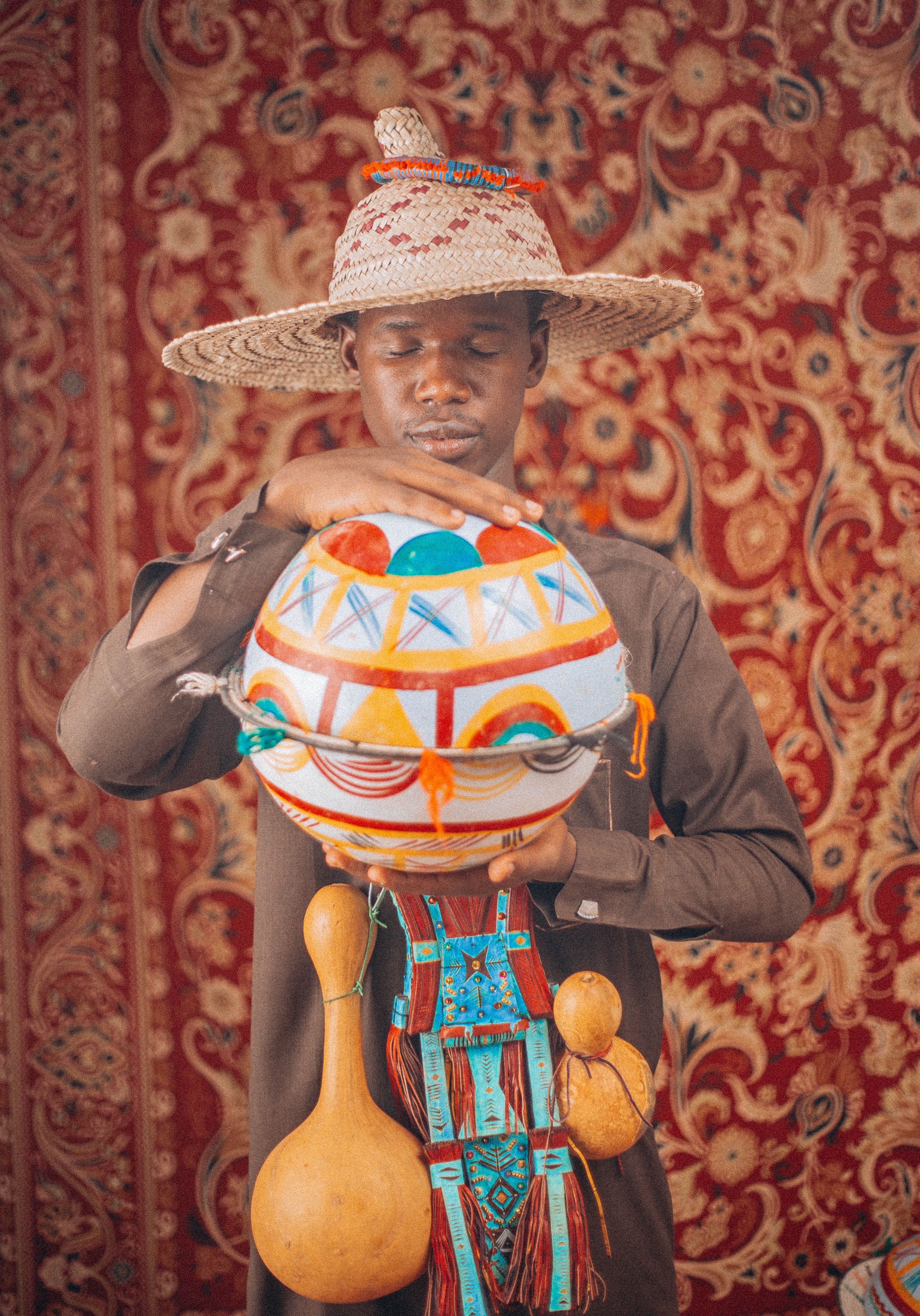Traditional African Attire with Decorative Gourd · Free Stock Photo