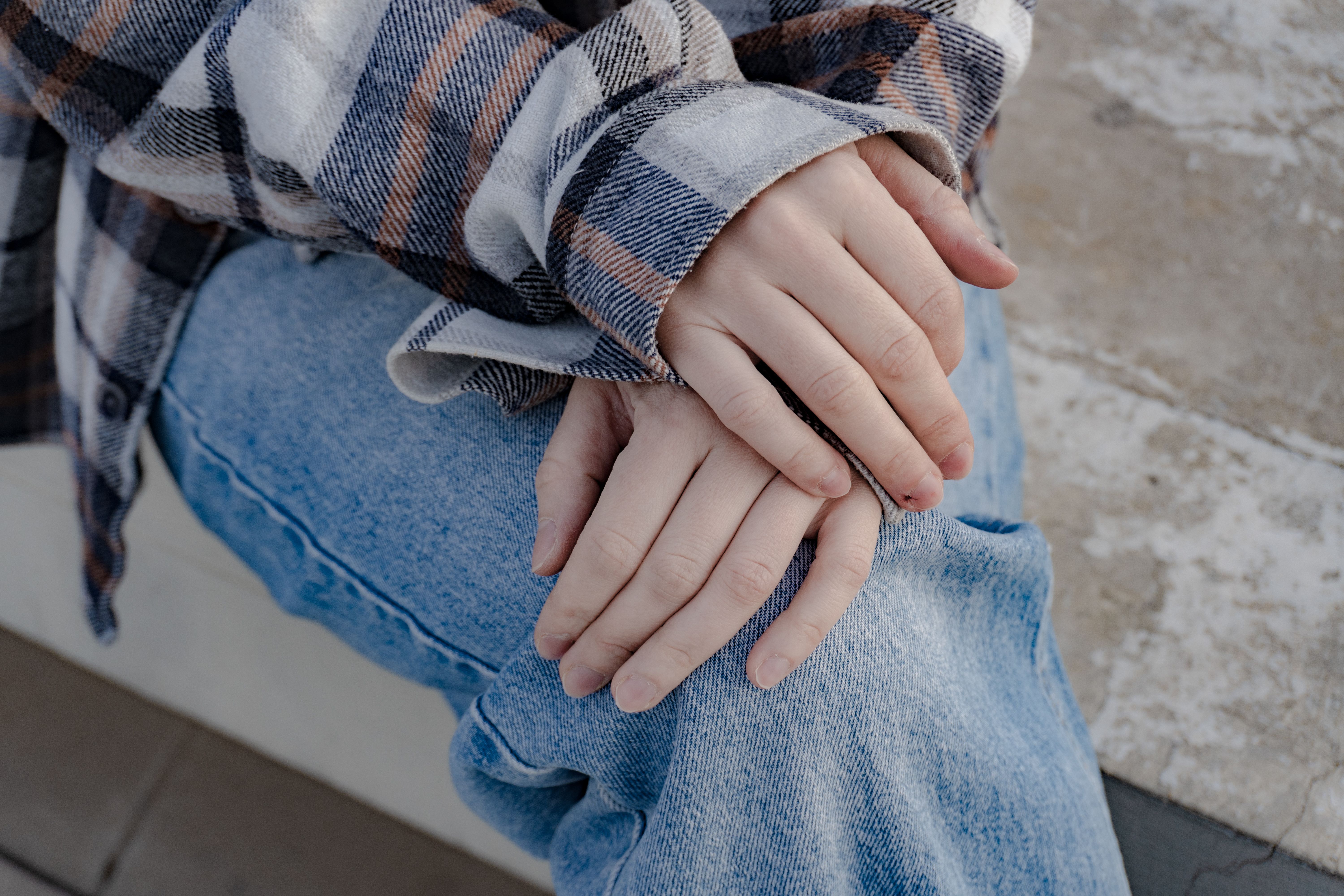 Close-Up of Hands Resting on Denim Jeans · Free Stock Photo
