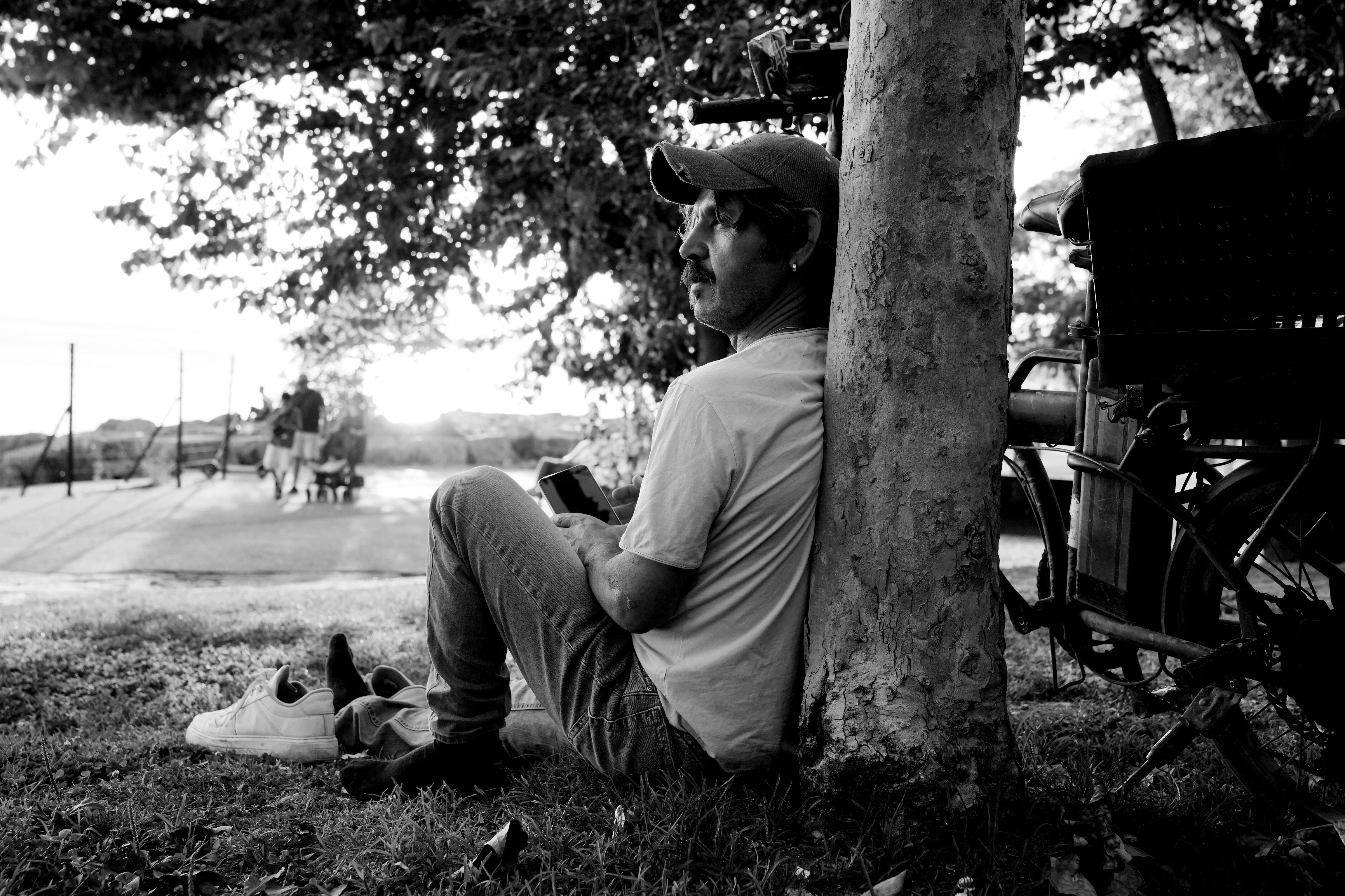 Man Relaxing Against Tree in Black and White Serenade · Free Stock Photo