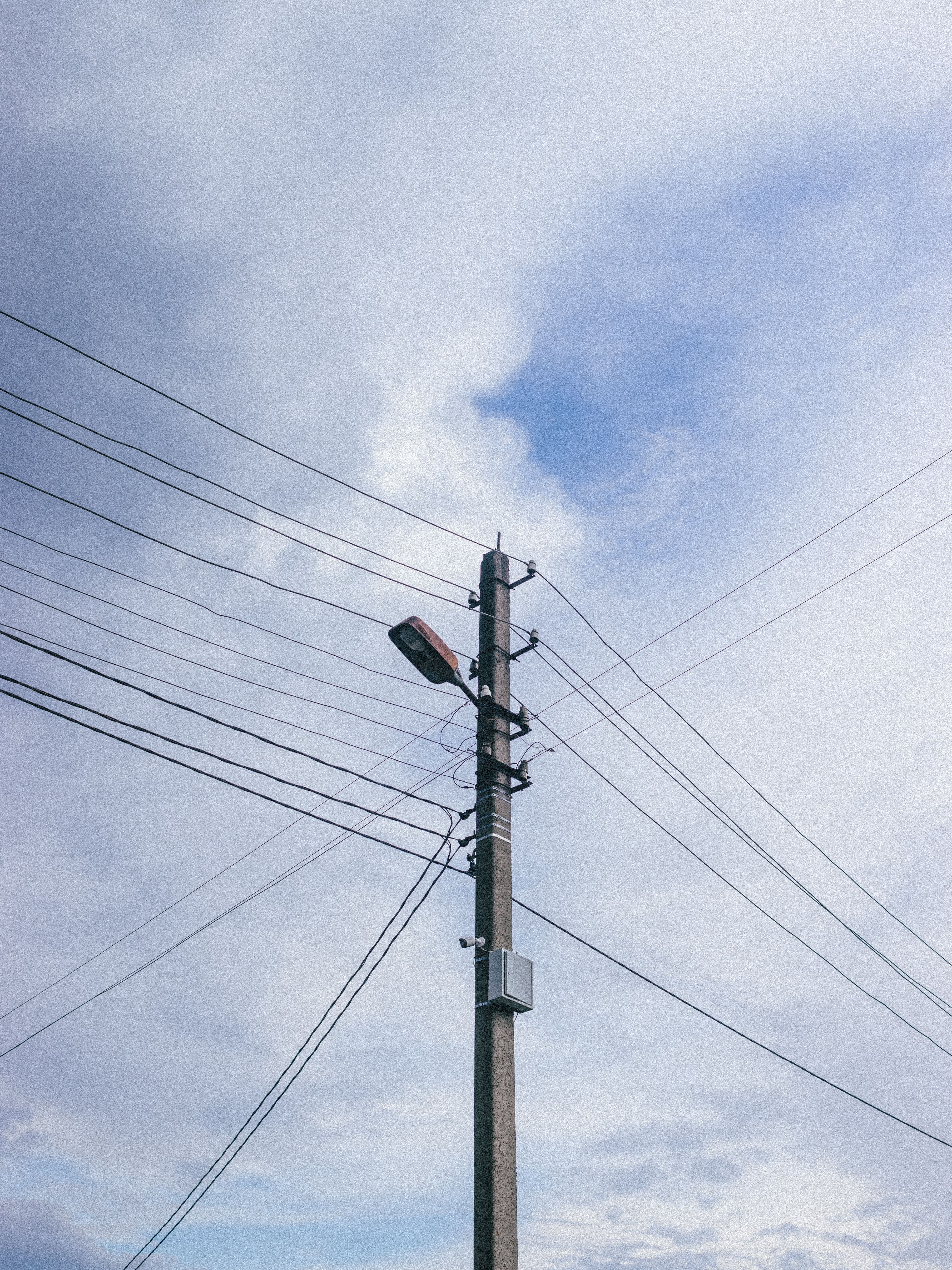 Tall utility pole under blue sky with clouds · Free Stock Photo
