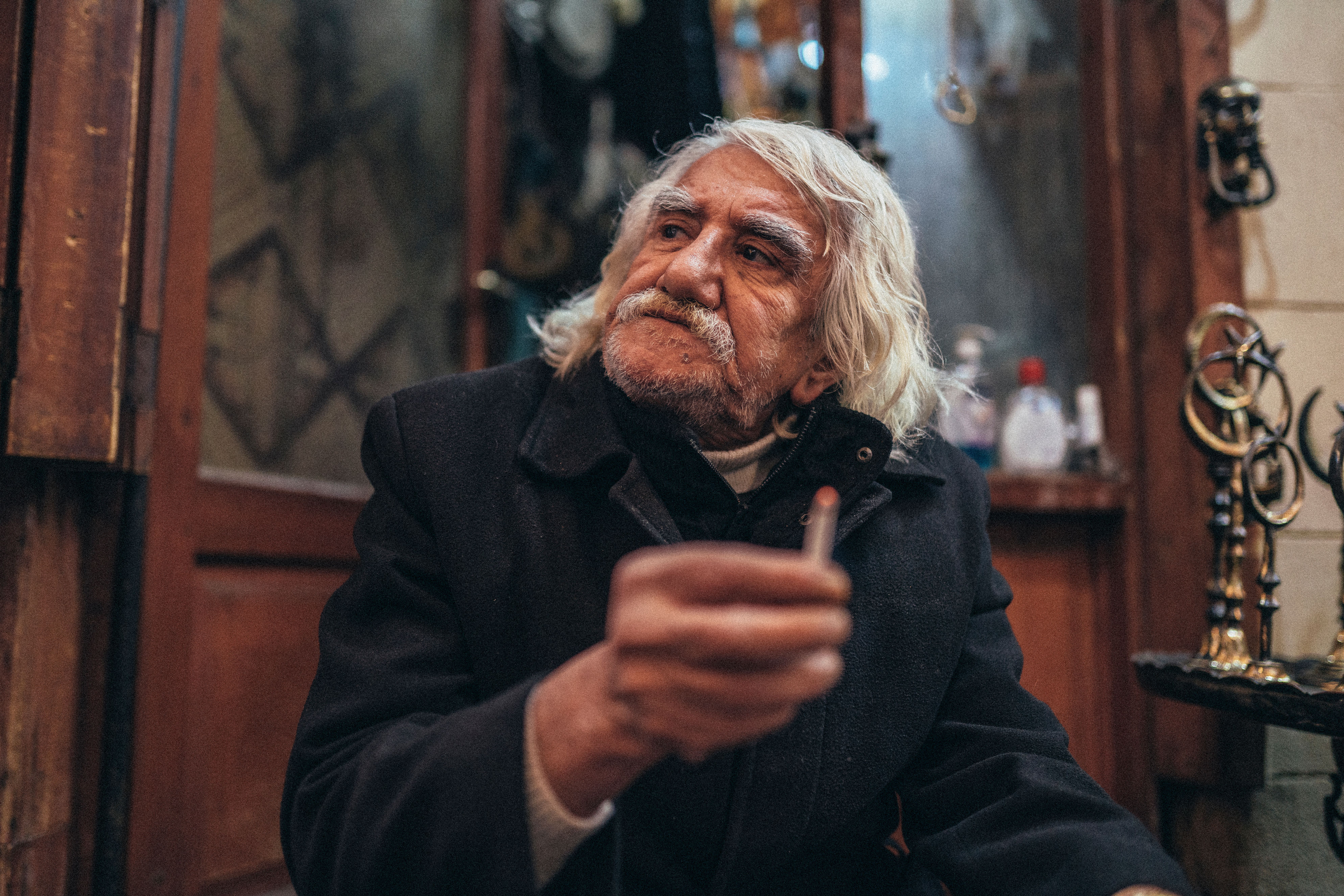 Elderly Man in Cozy Room Holding Object · Free Stock Photo