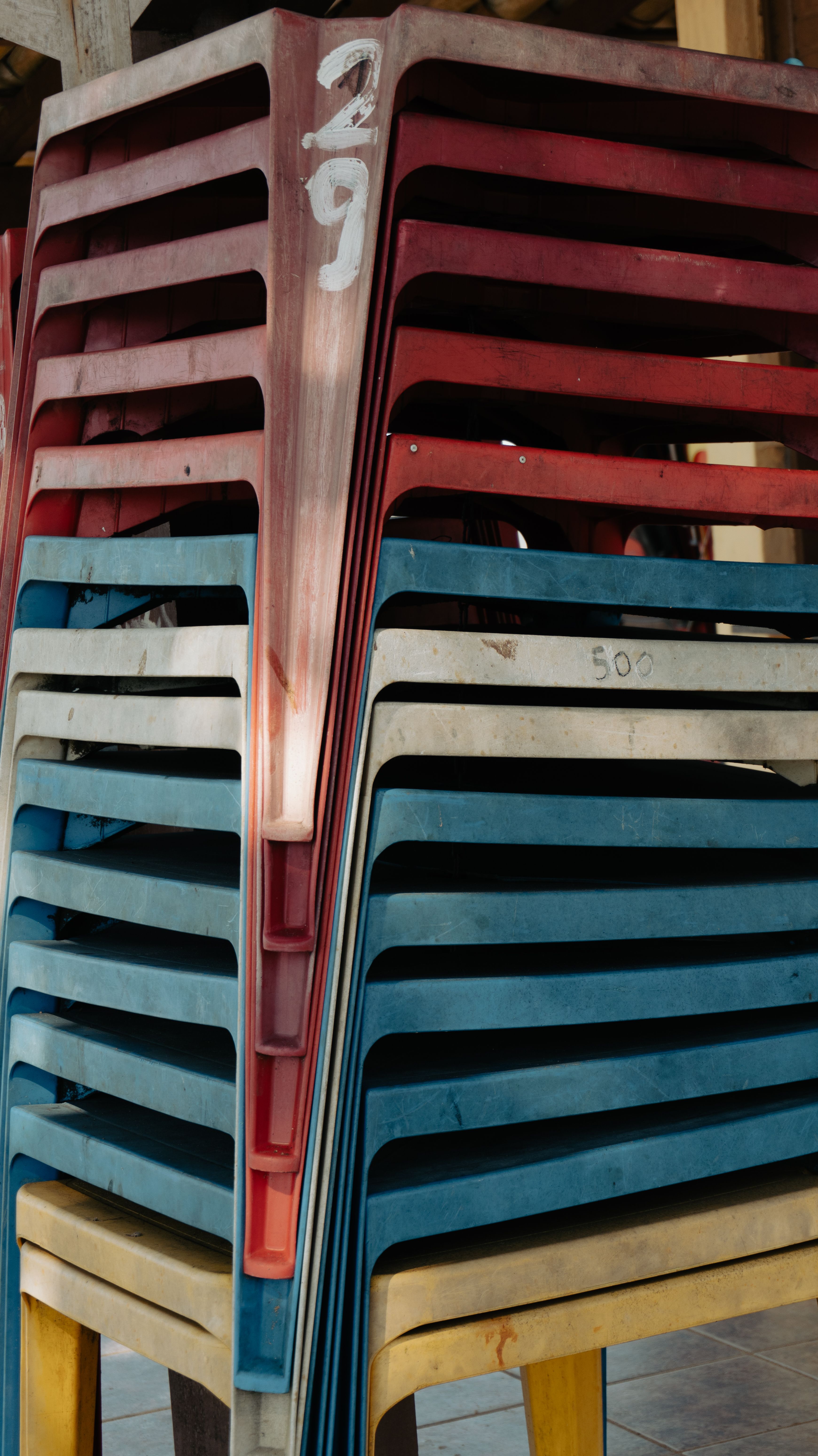 Stacked Colorful Plastic Chairs Indoors · Free Stock Photo