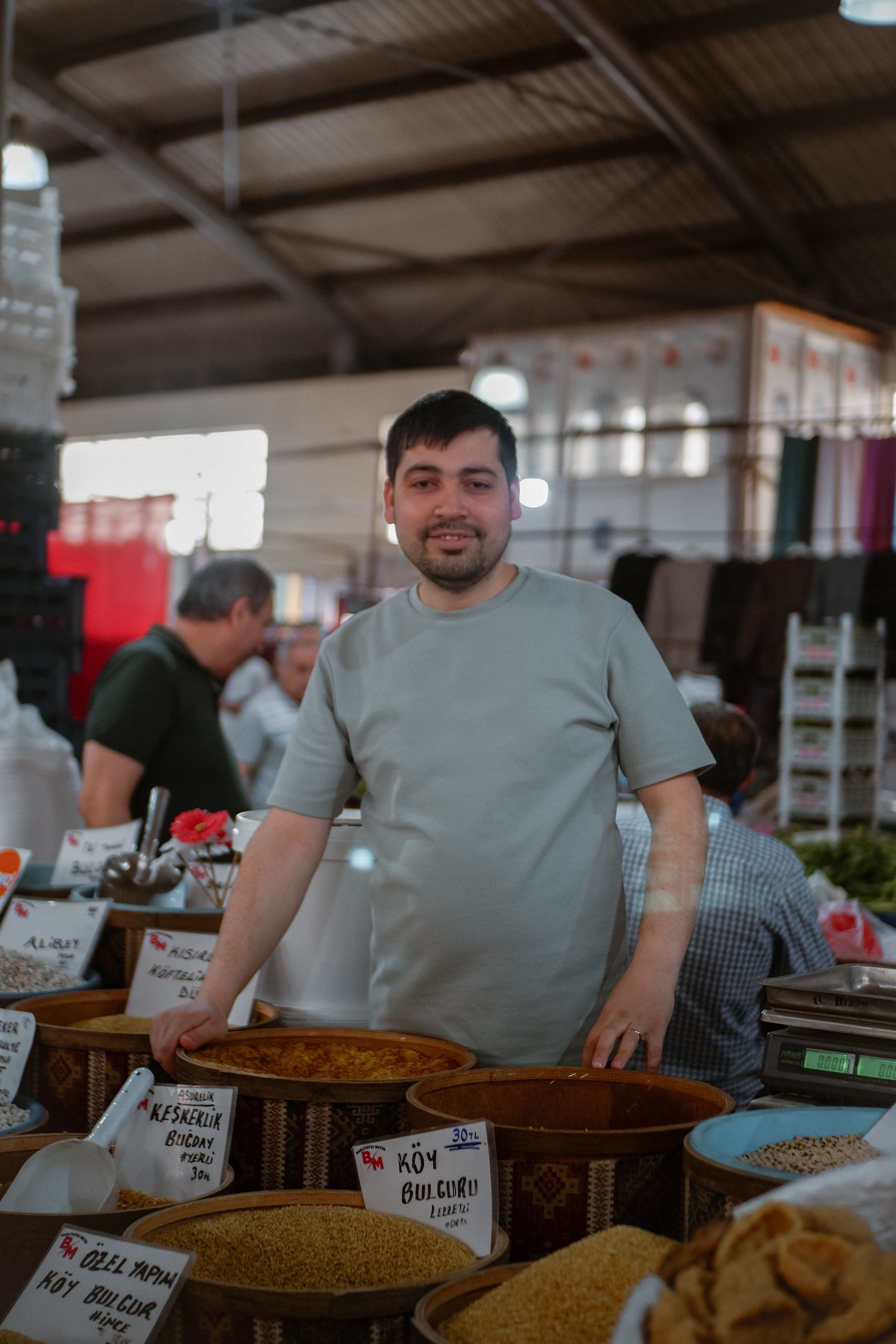 Man selling grains at a bustling market · Free Stock Photo