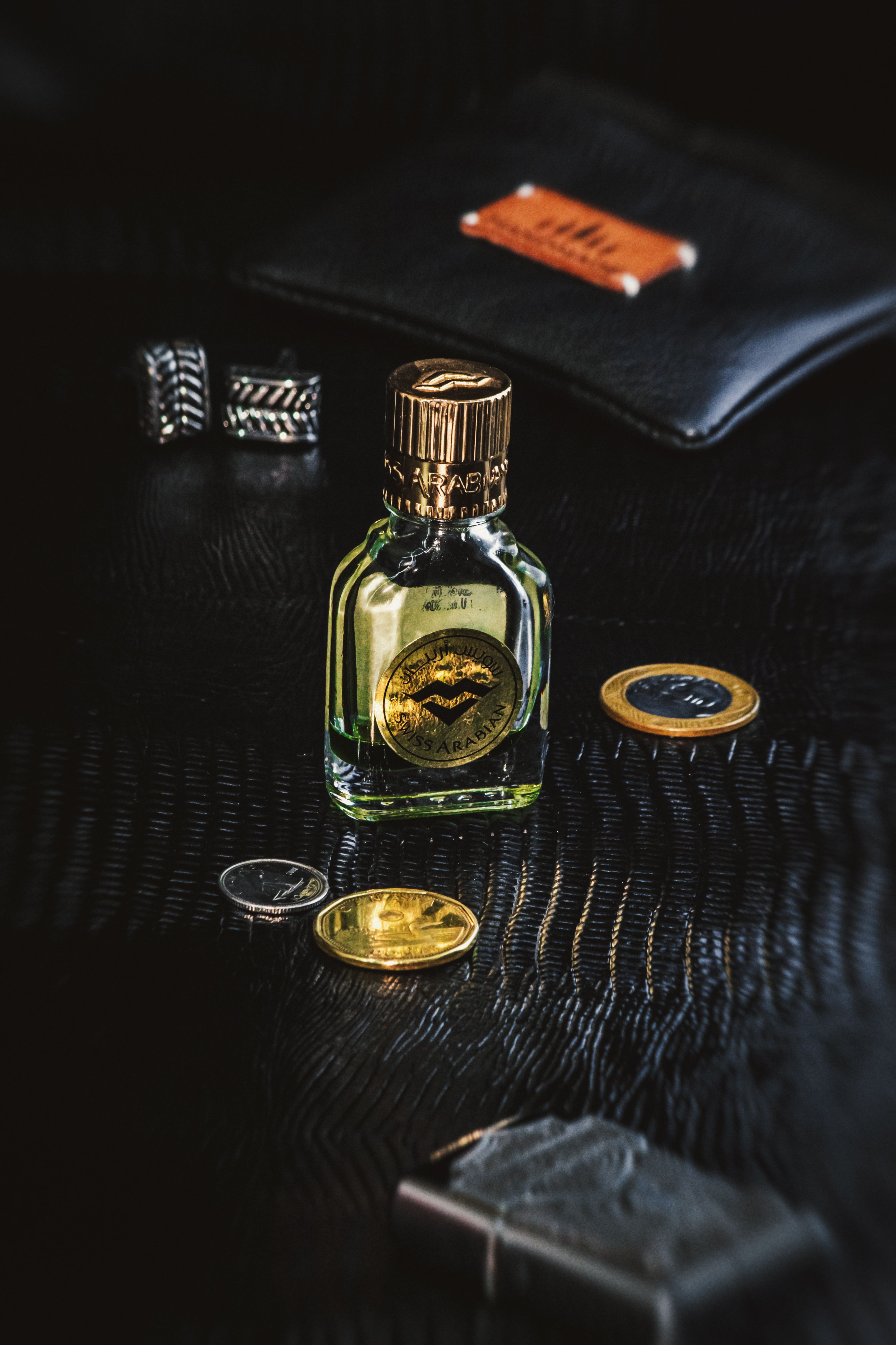 Luxury Perfume with Coins and Accessories Display · Free Stock Photo