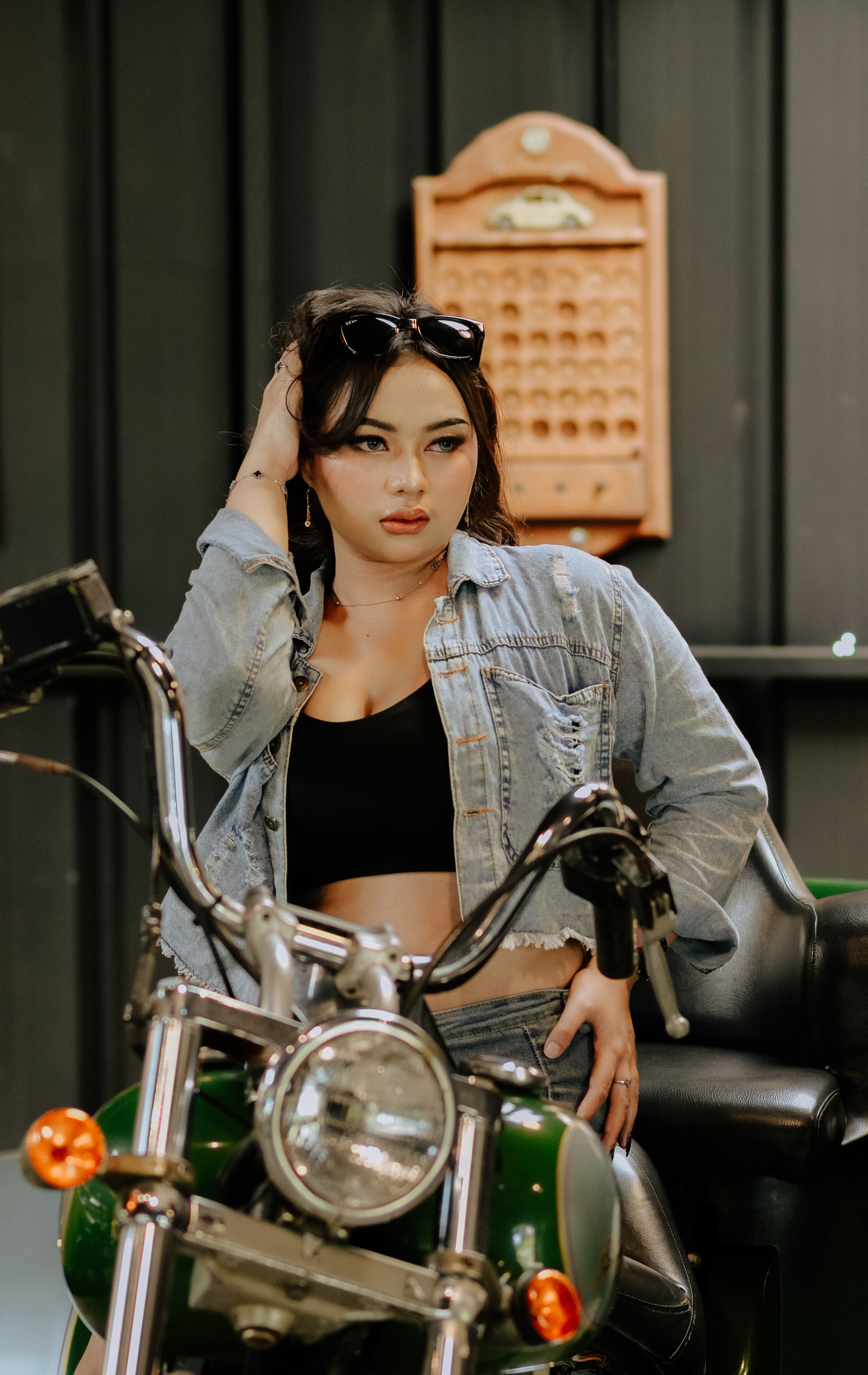 Stylish Female Model Posing on Motorcycle Indoors · Free Stock Photo