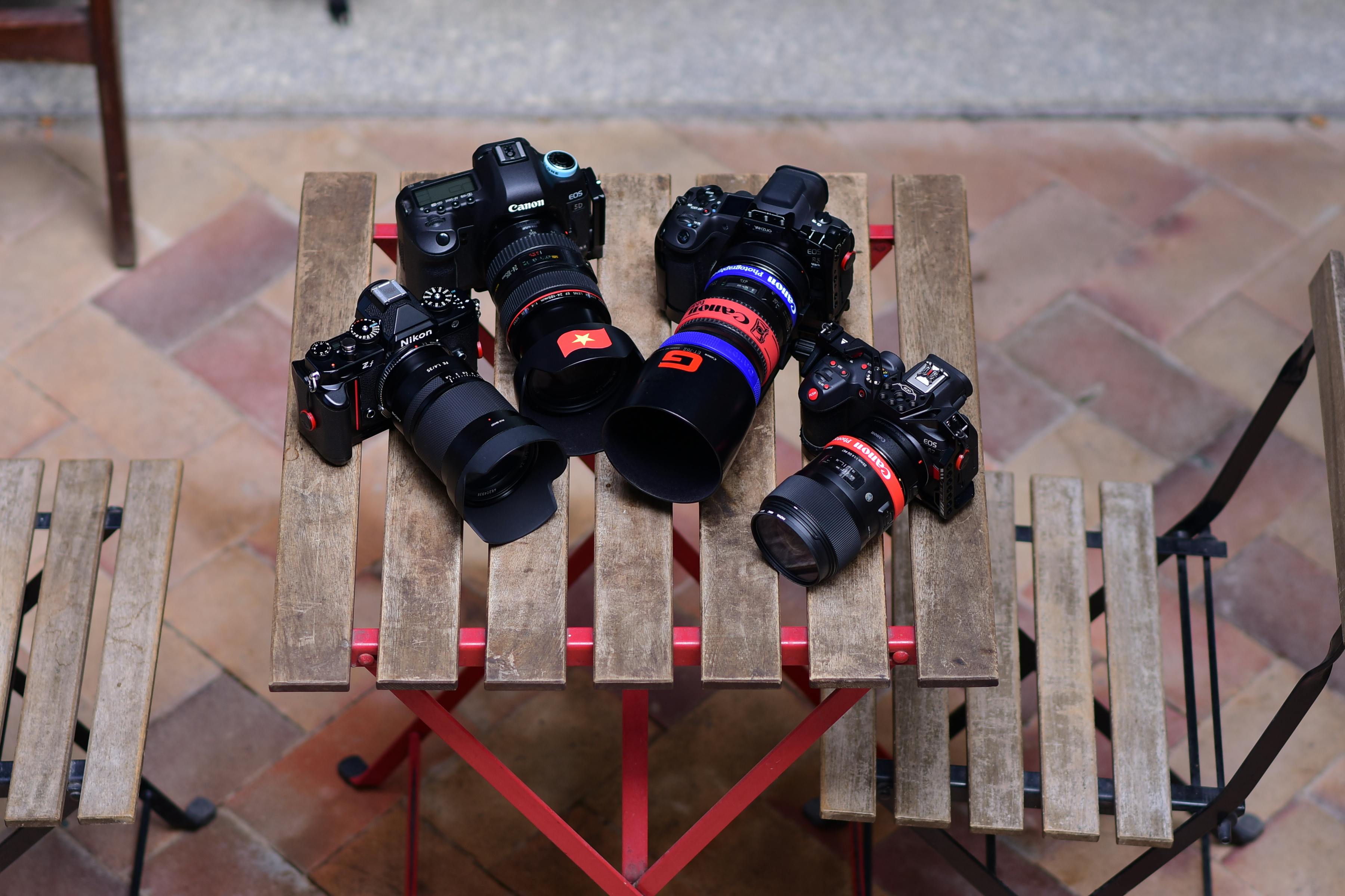Collection of DSLR Cameras on Rustic Table · Free Stock Photo