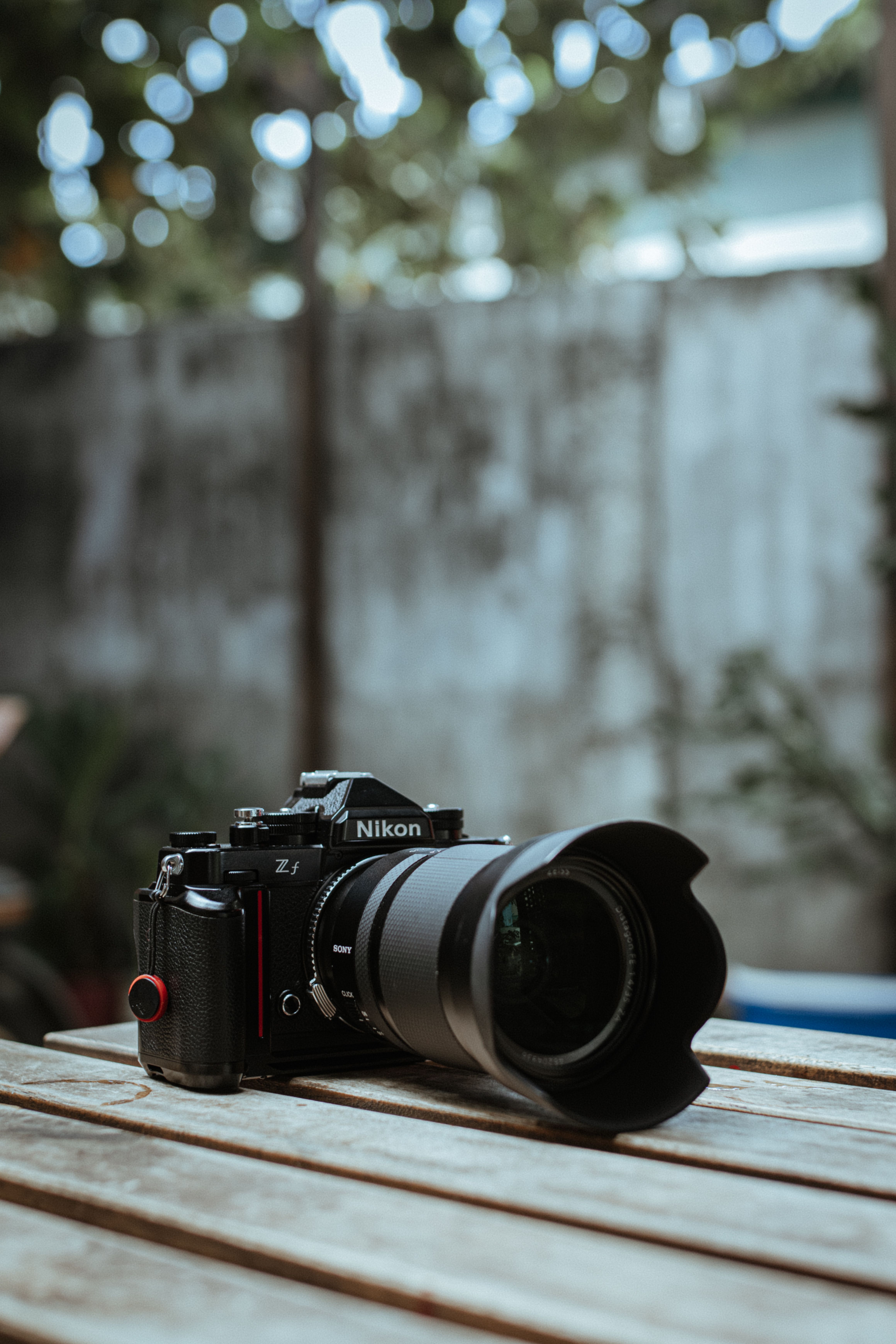 Professional DSLR Camera on Wooden Table Outdoors · Free Stock Photo