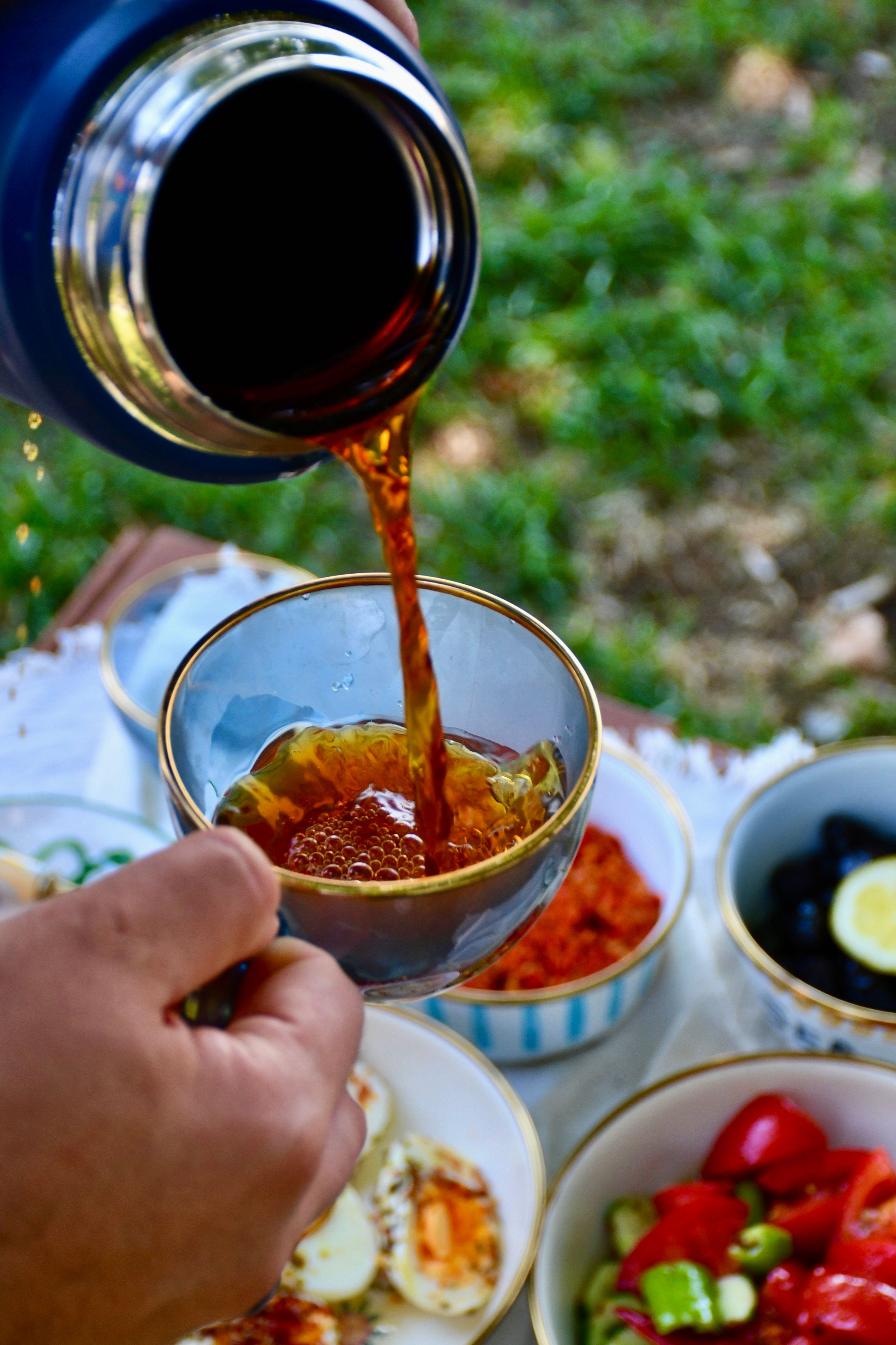 Vibrant Outdoor Picnic with Tea Pouring Moment · Free Stock Photo