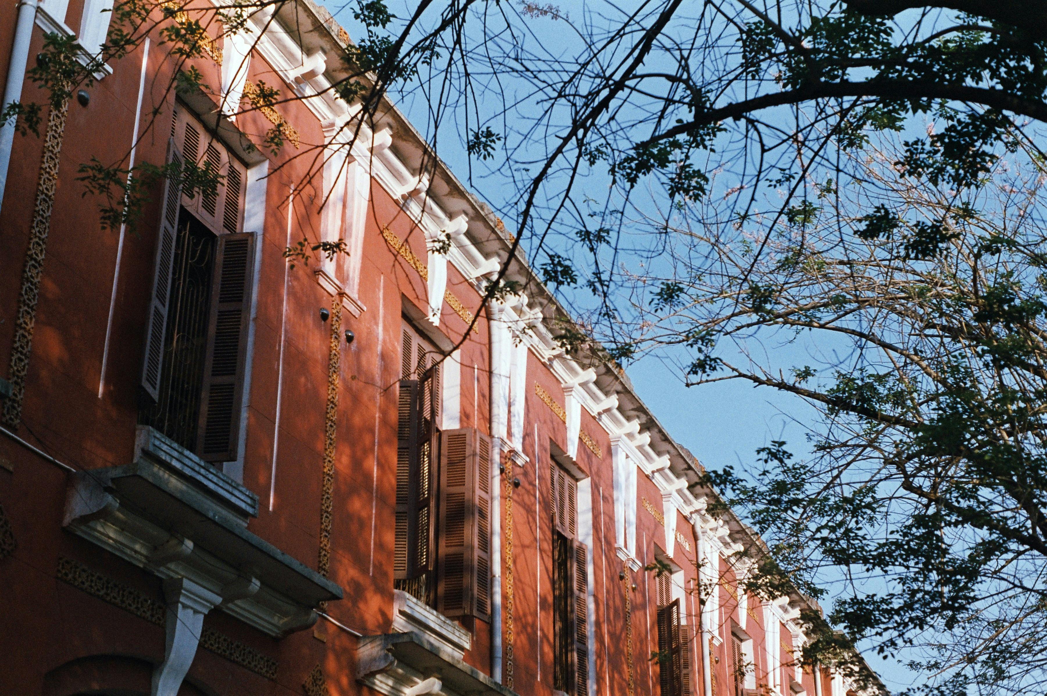 Historic Red Building with Open Shutters · Free Stock Photo