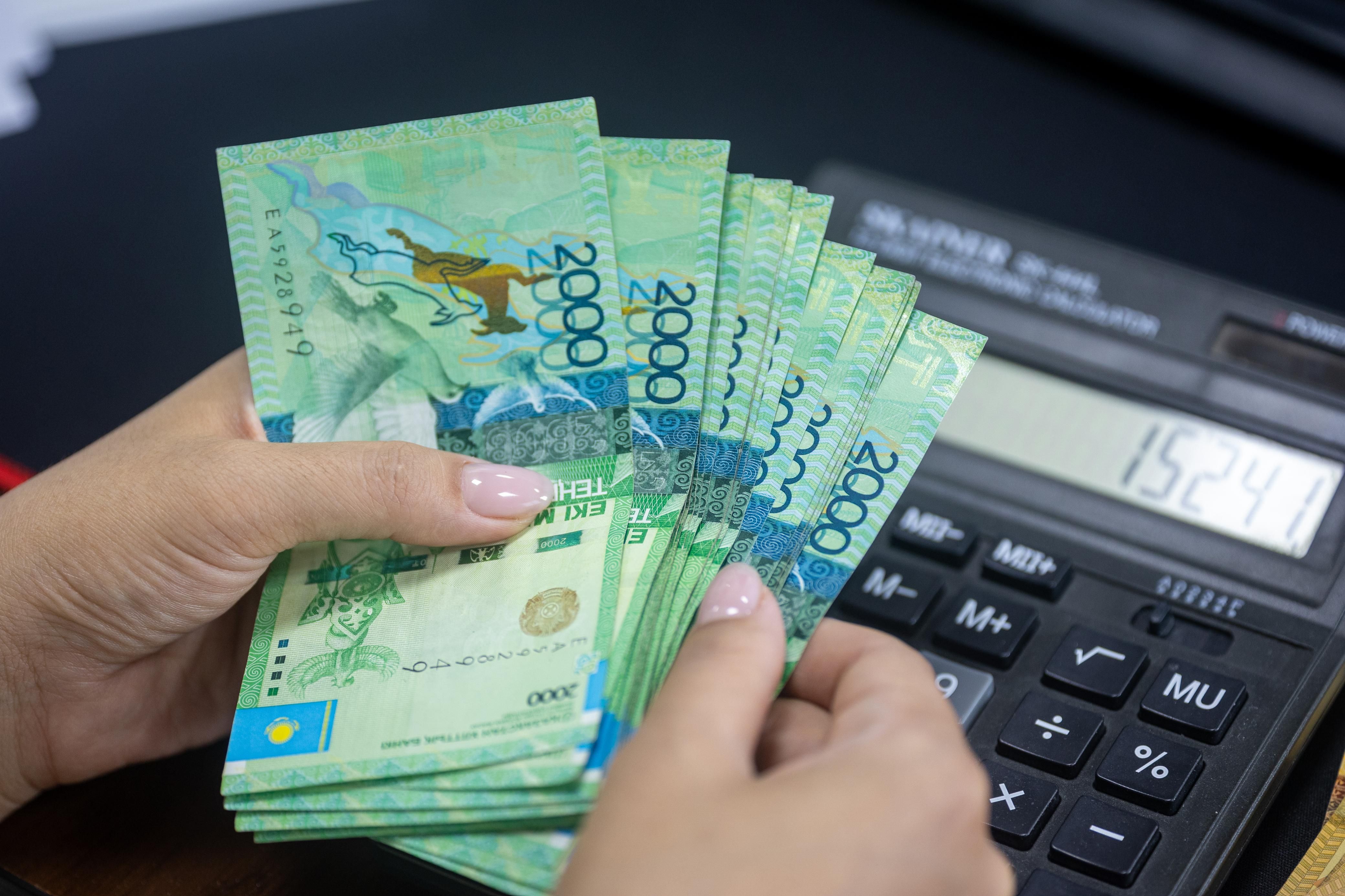 Counting Kazakhstani Tenge Notes with Calculator · Free Stock Photo