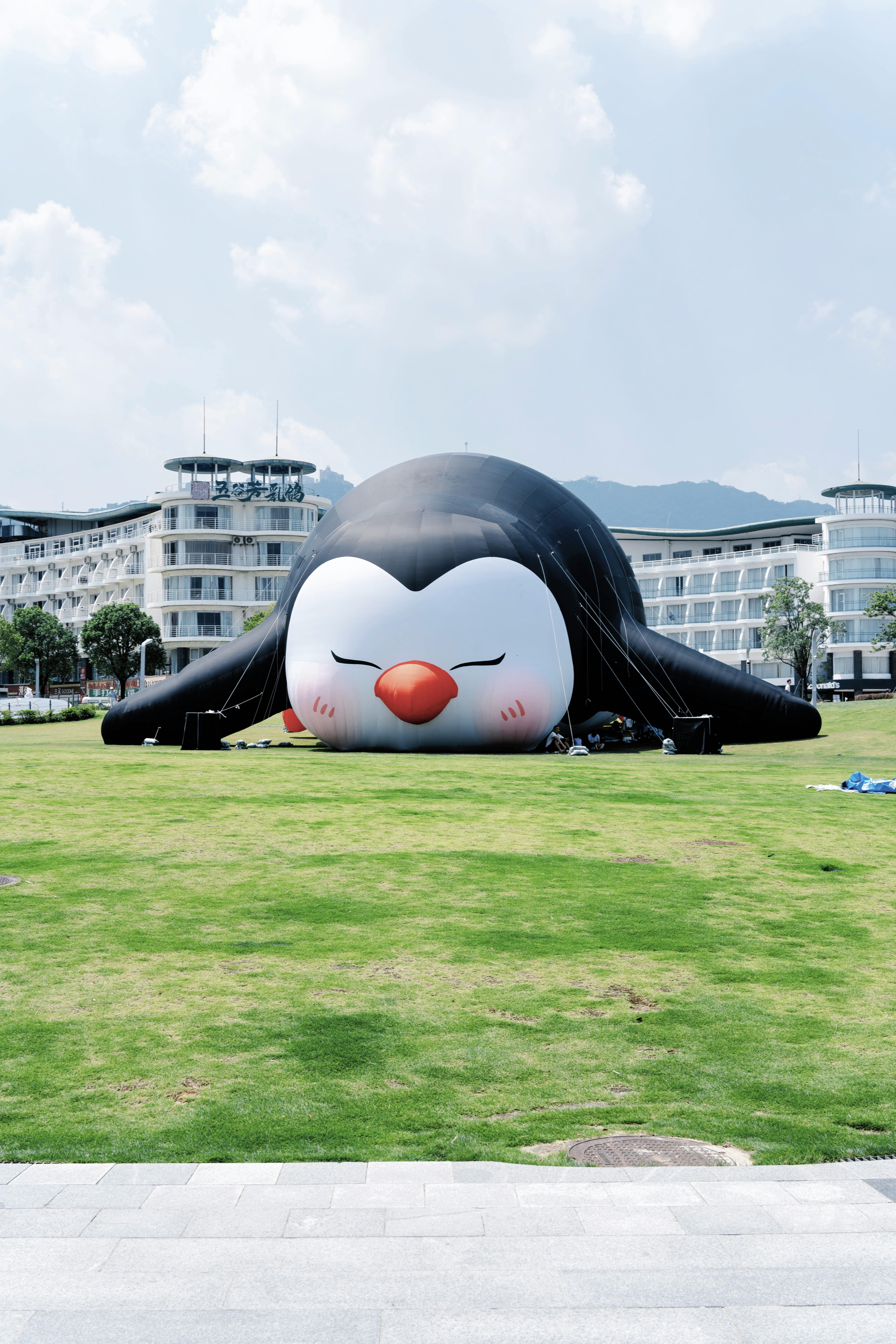 Giant Inflatable Penguin on Green Lawn Outdoors · Free Stock Photo