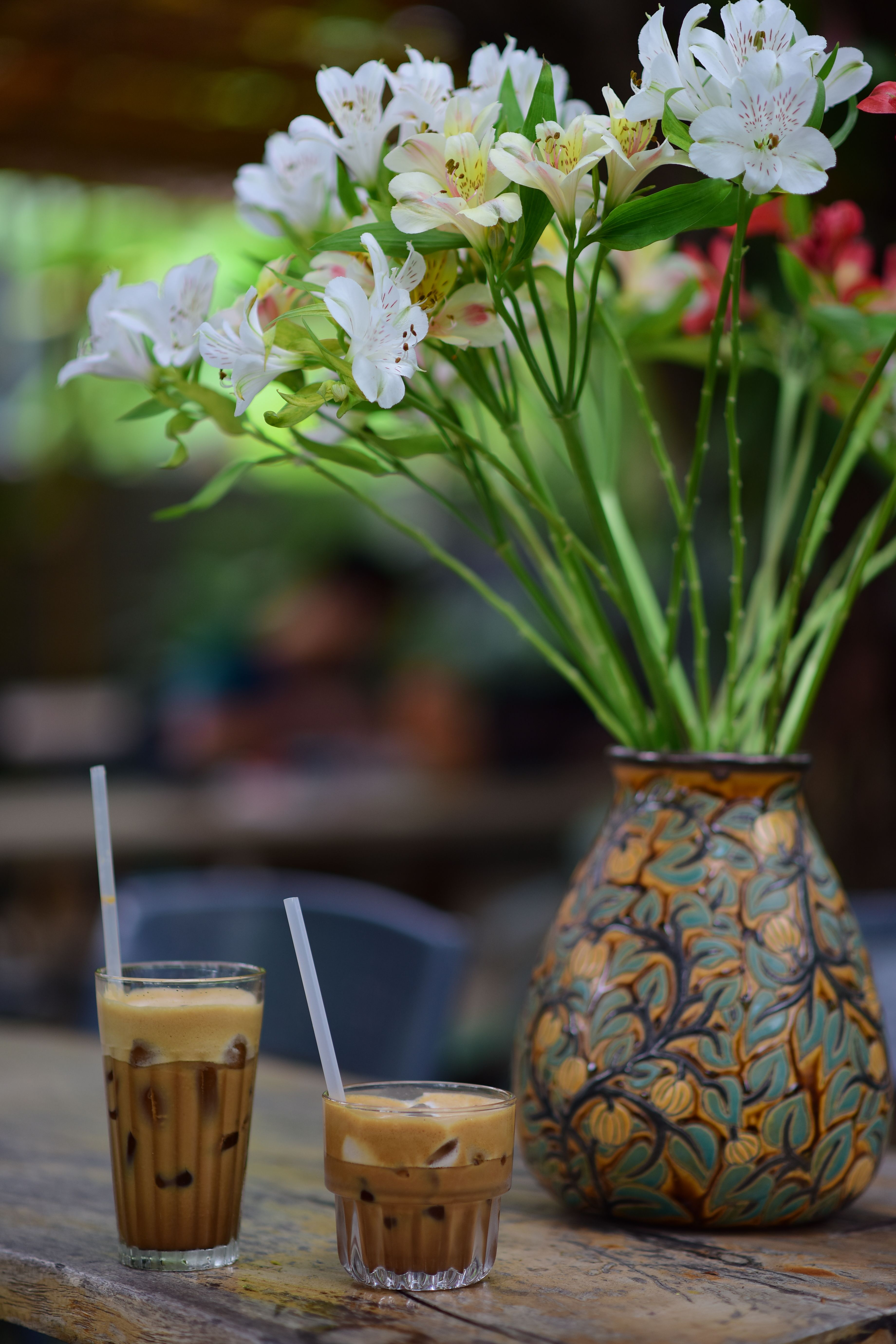 Rustic outdoor café table with flowers and iced coffee · Free Stock Photo
