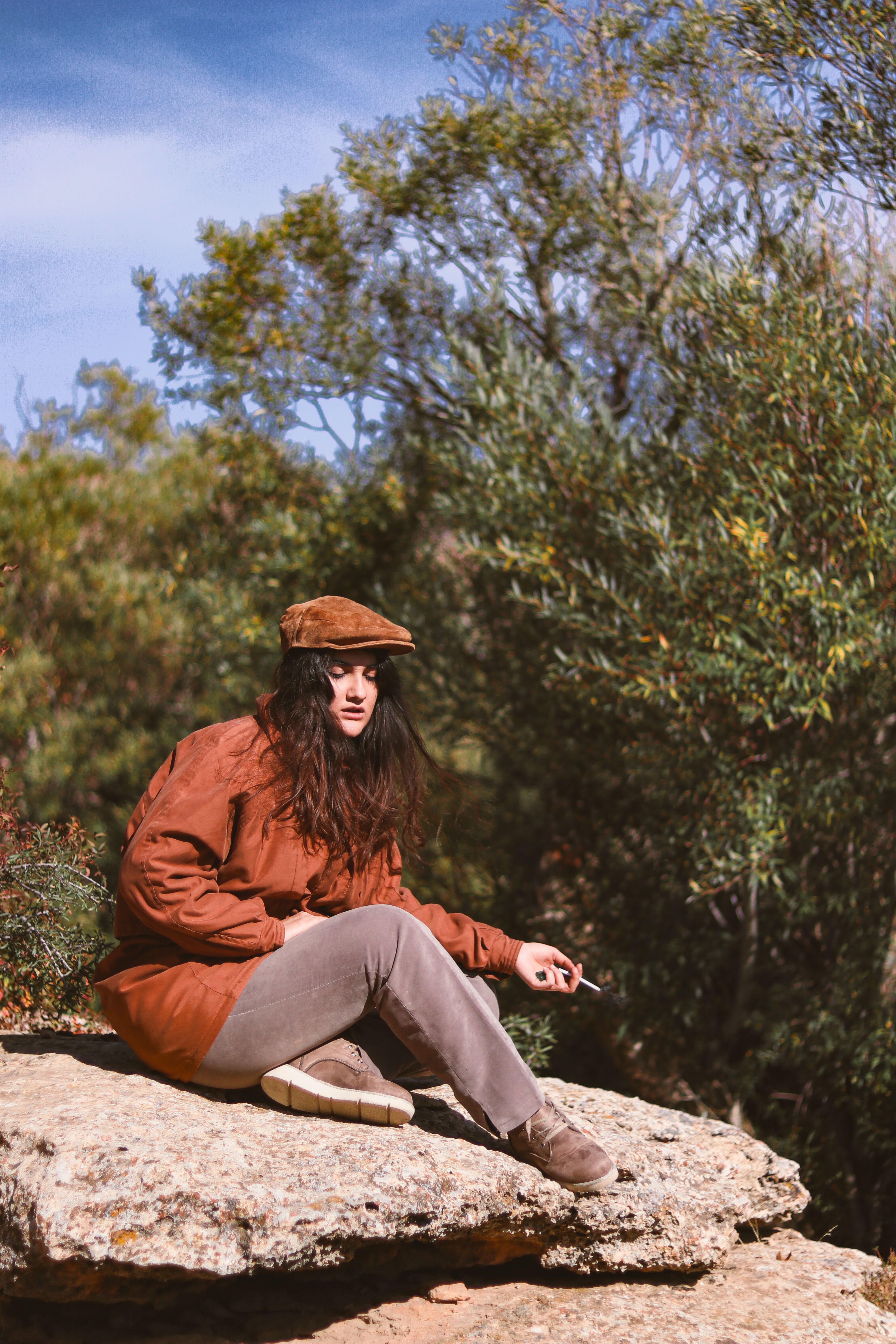 Young Woman Relaxing on Rocky Outcrop Outdoors · Free Stock Photo