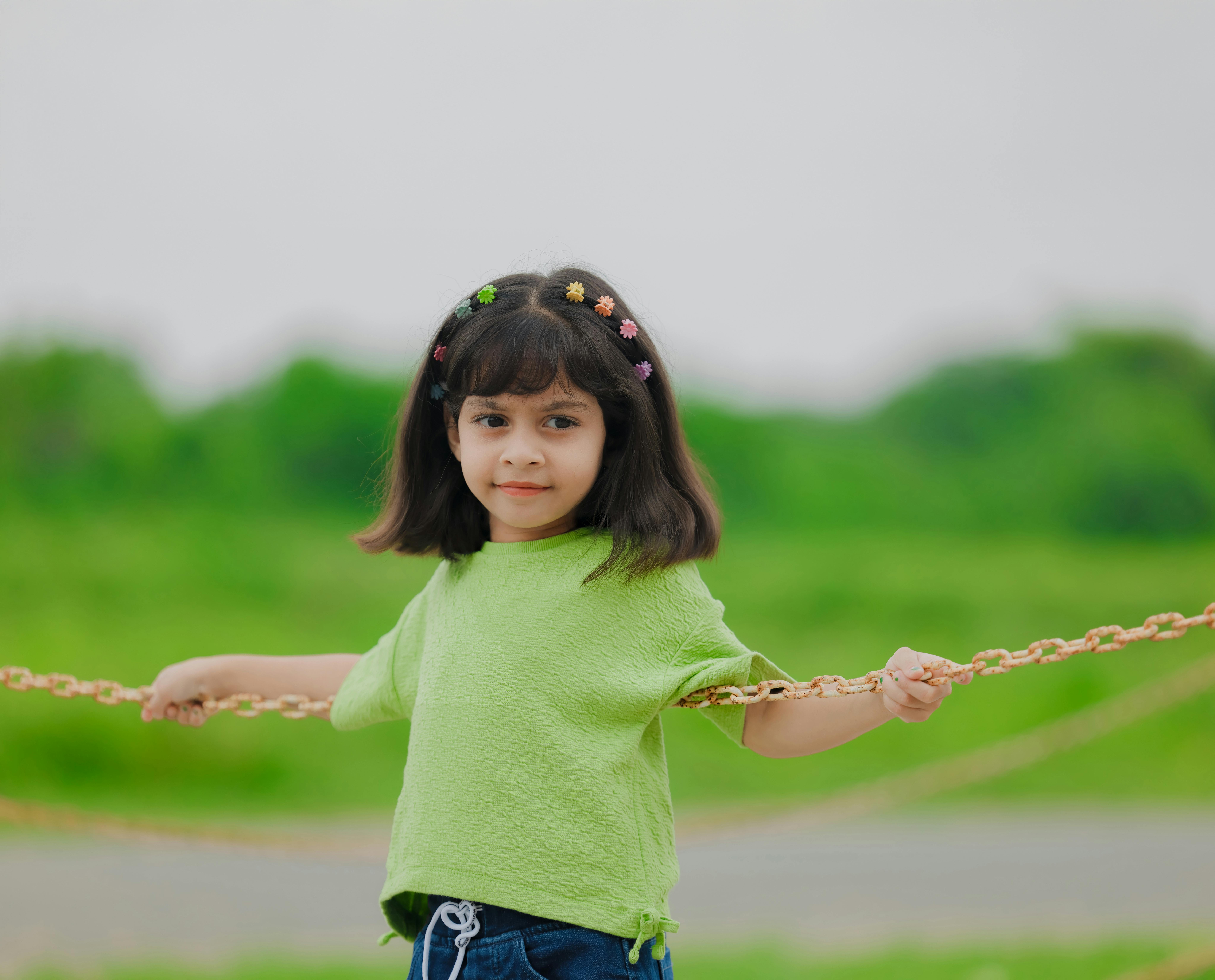 Cute Child Holding Chain in Sunny Park · Free Stock Photo