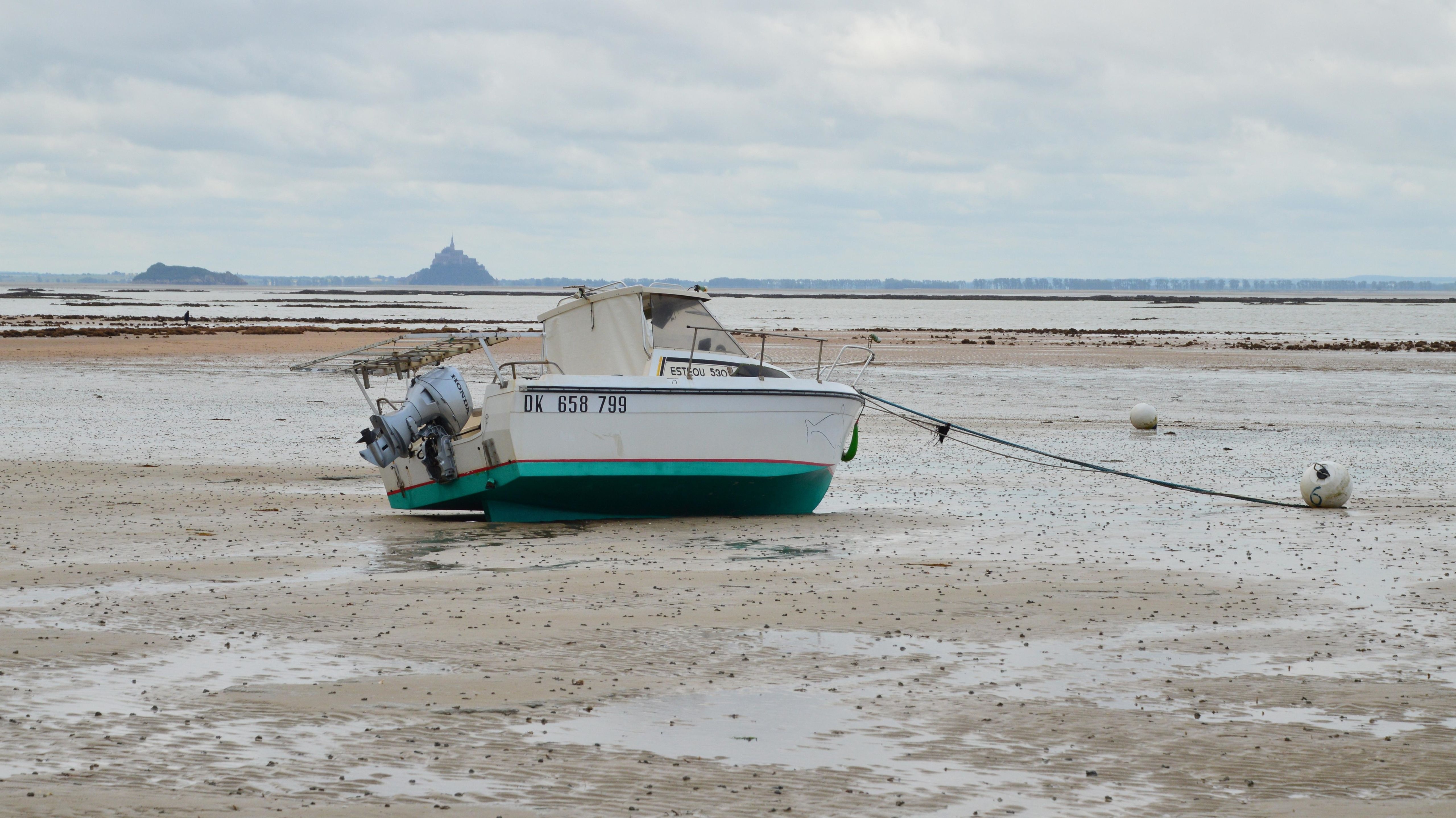 Beached Boat with Mont Saint-Michel in Background · Free Stock Photo