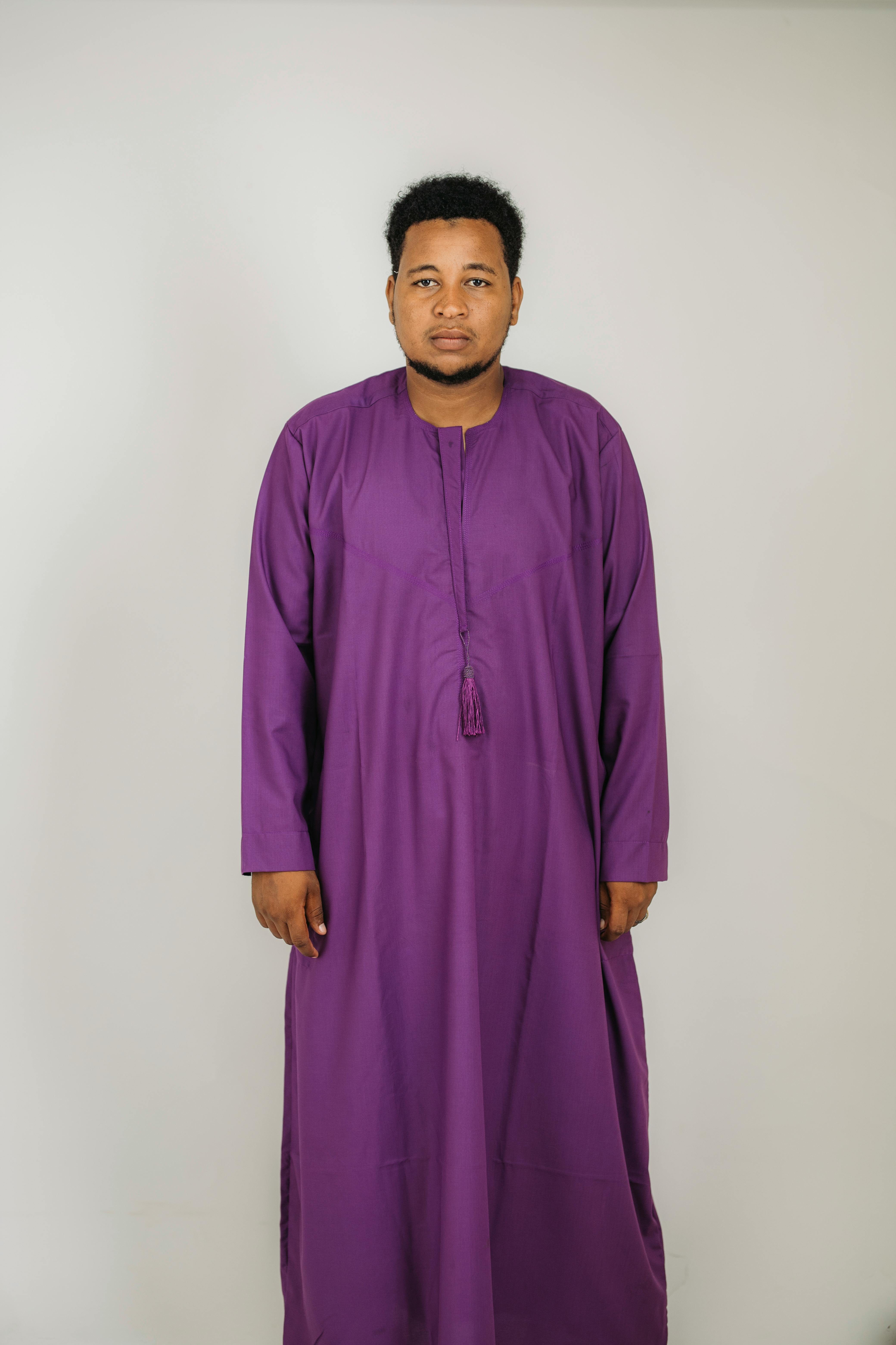 Man in Traditional Purple Thobe on Simple Background · Free Stock Photo