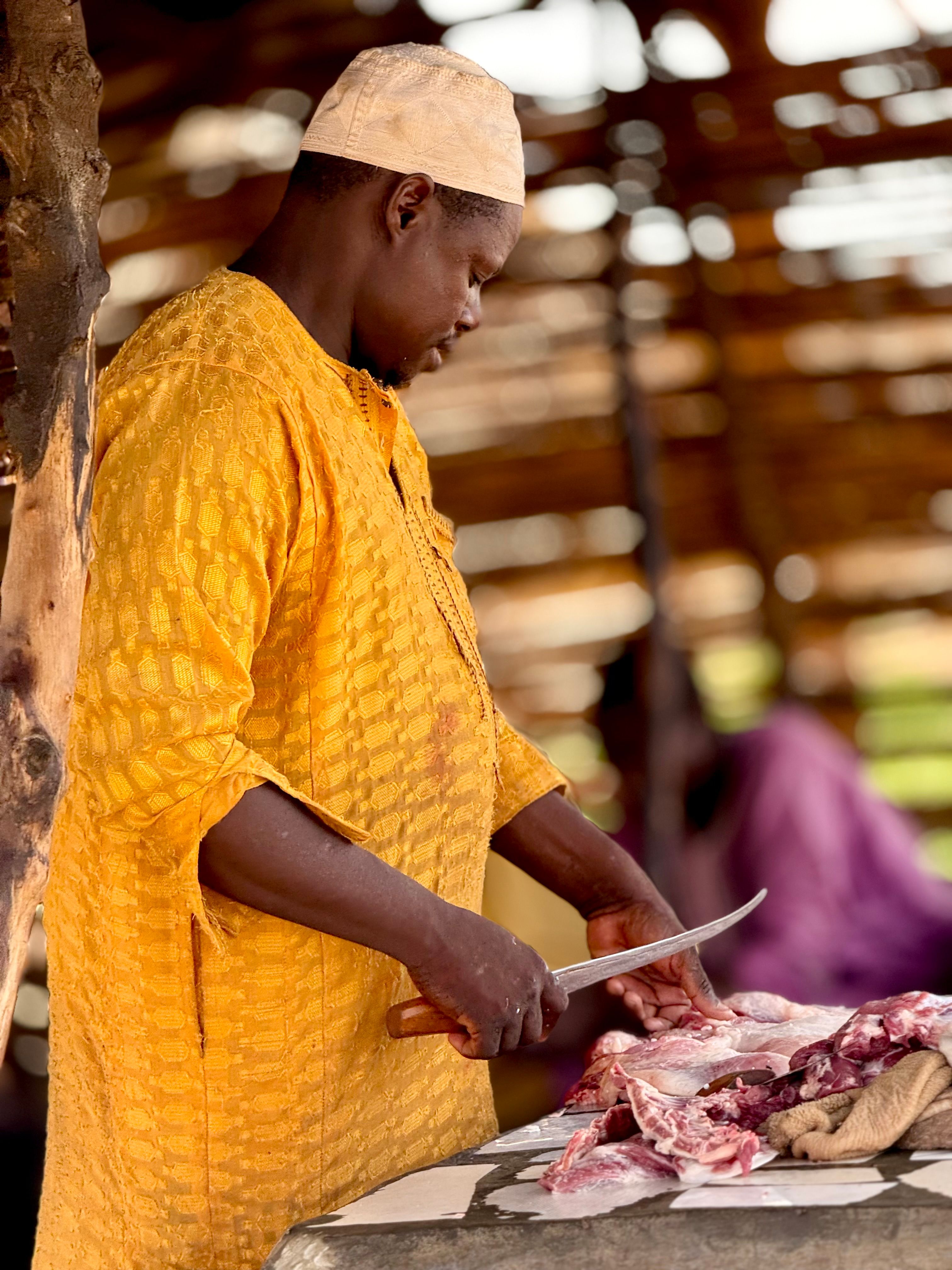 Butcher Preparing Meat at Outdoor Market in Nigeria · Free Stock Photo