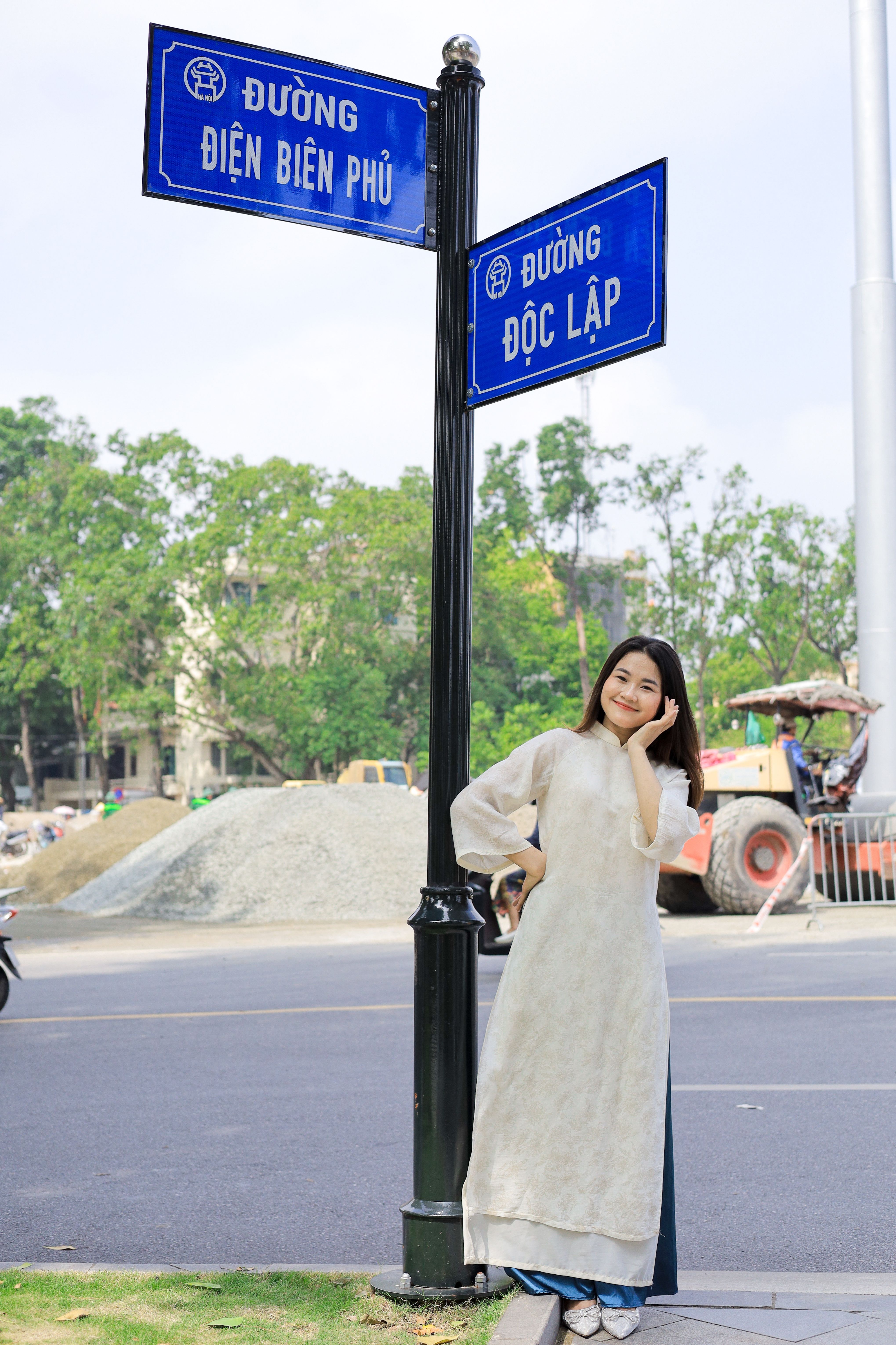 Vietnamese Woman in Ao Dai Near Street Signs · Free Stock Photo