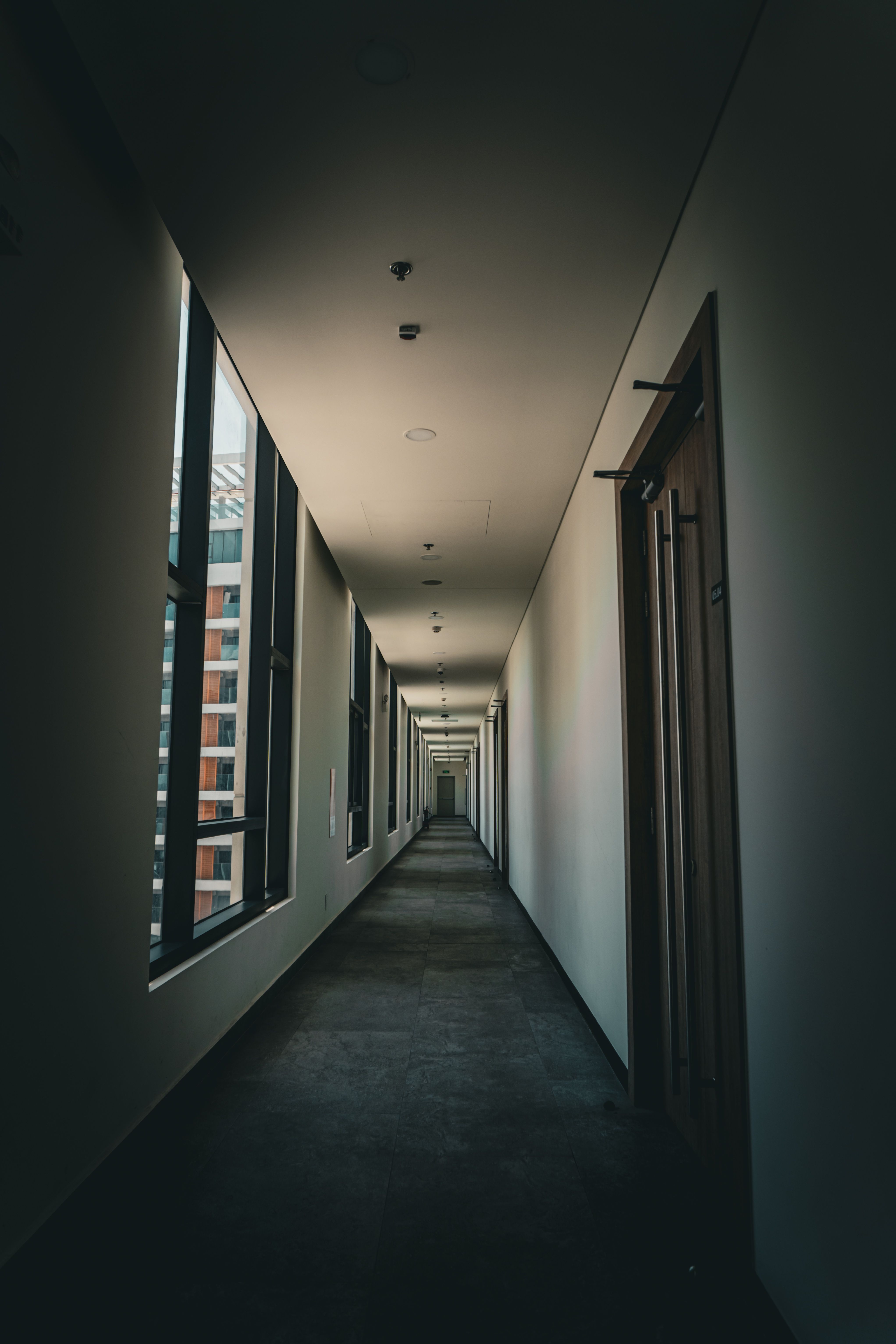 Moody Indoor Hallway with Windows · Free Stock Photo