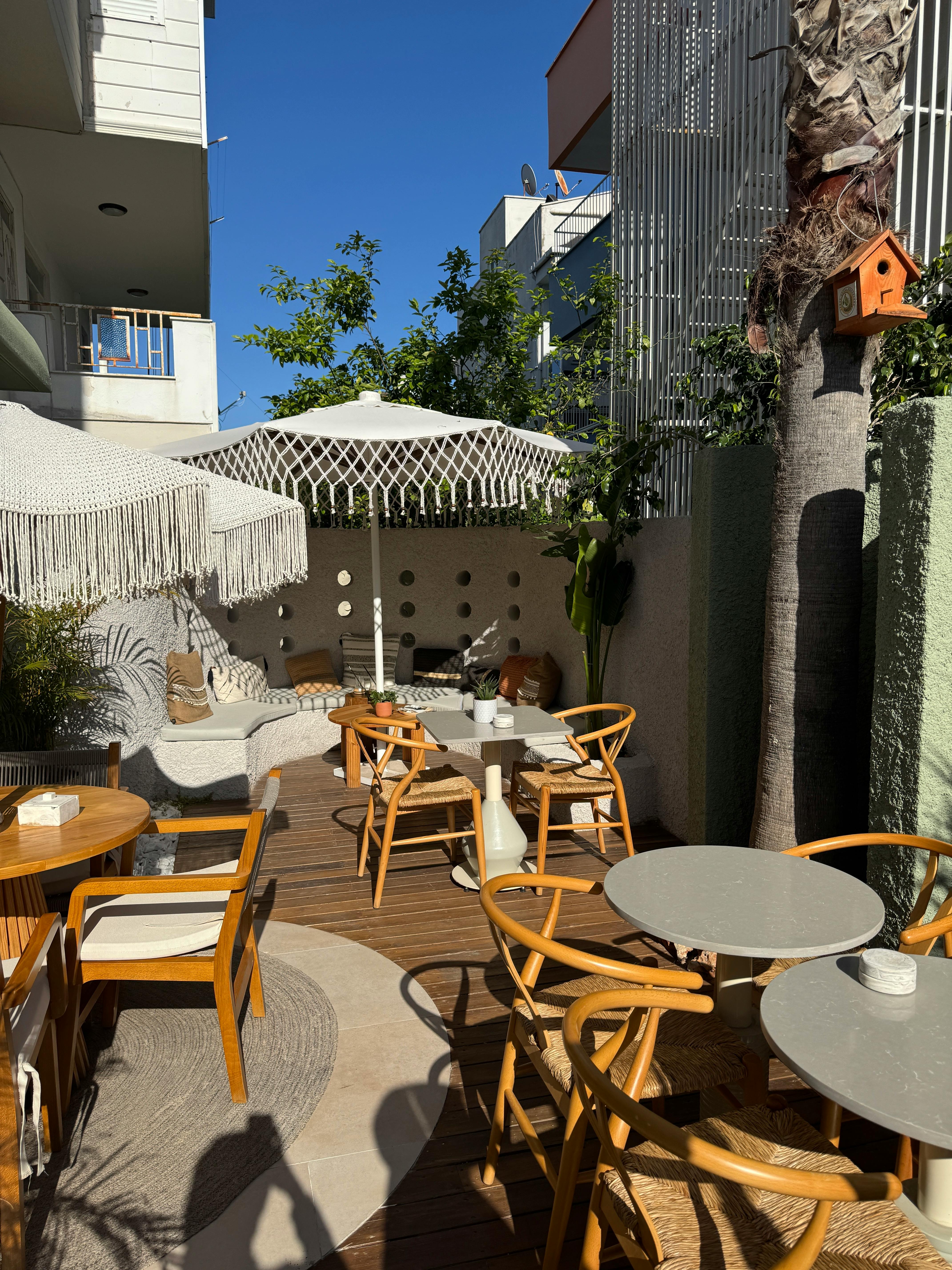 Sunny Outdoor Cafe with Cozy Decor and Seating · Free Stock Photo