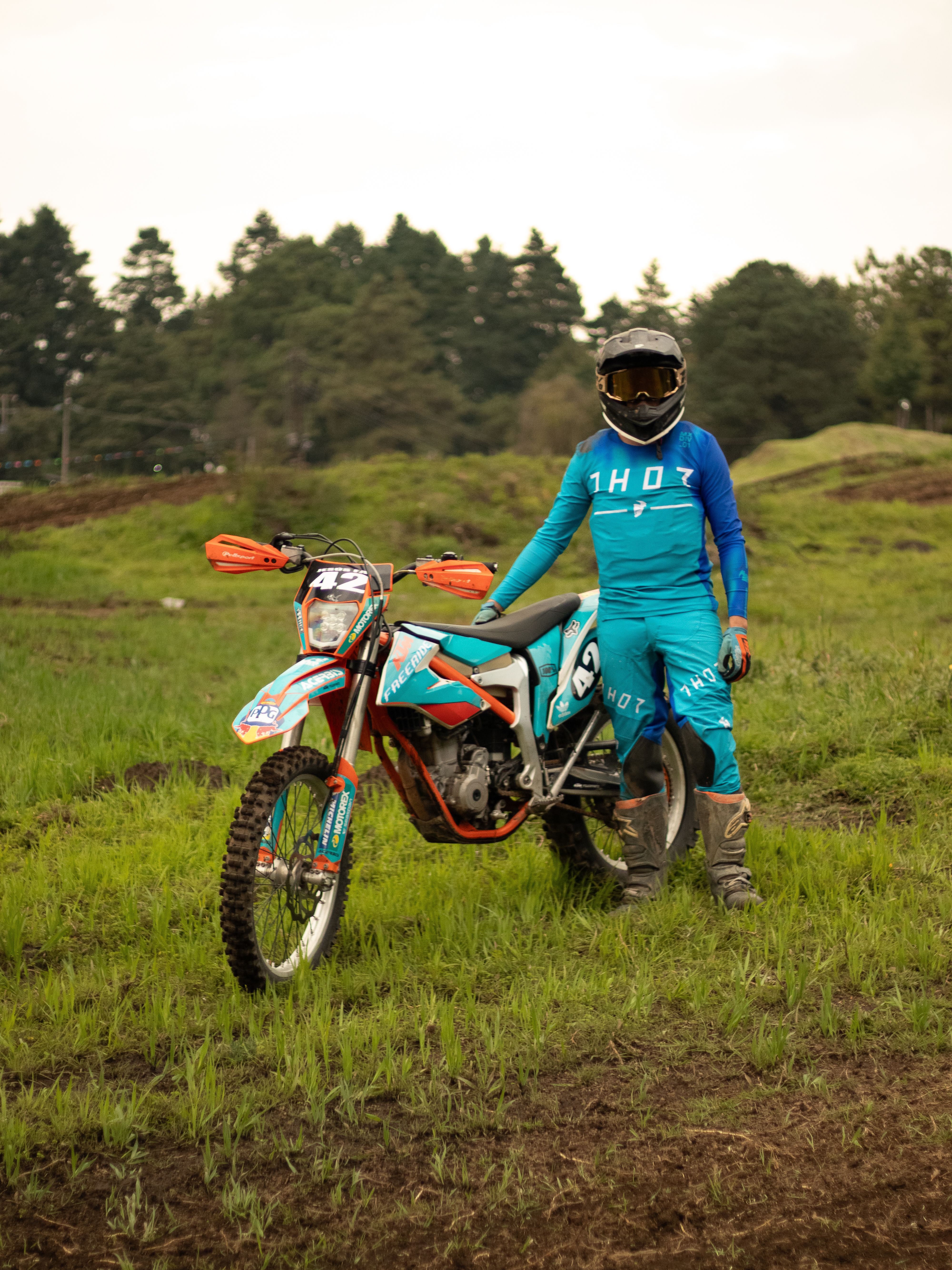Motocross Rider Posing with Dirt Bike in the Field · Free Stock Photo